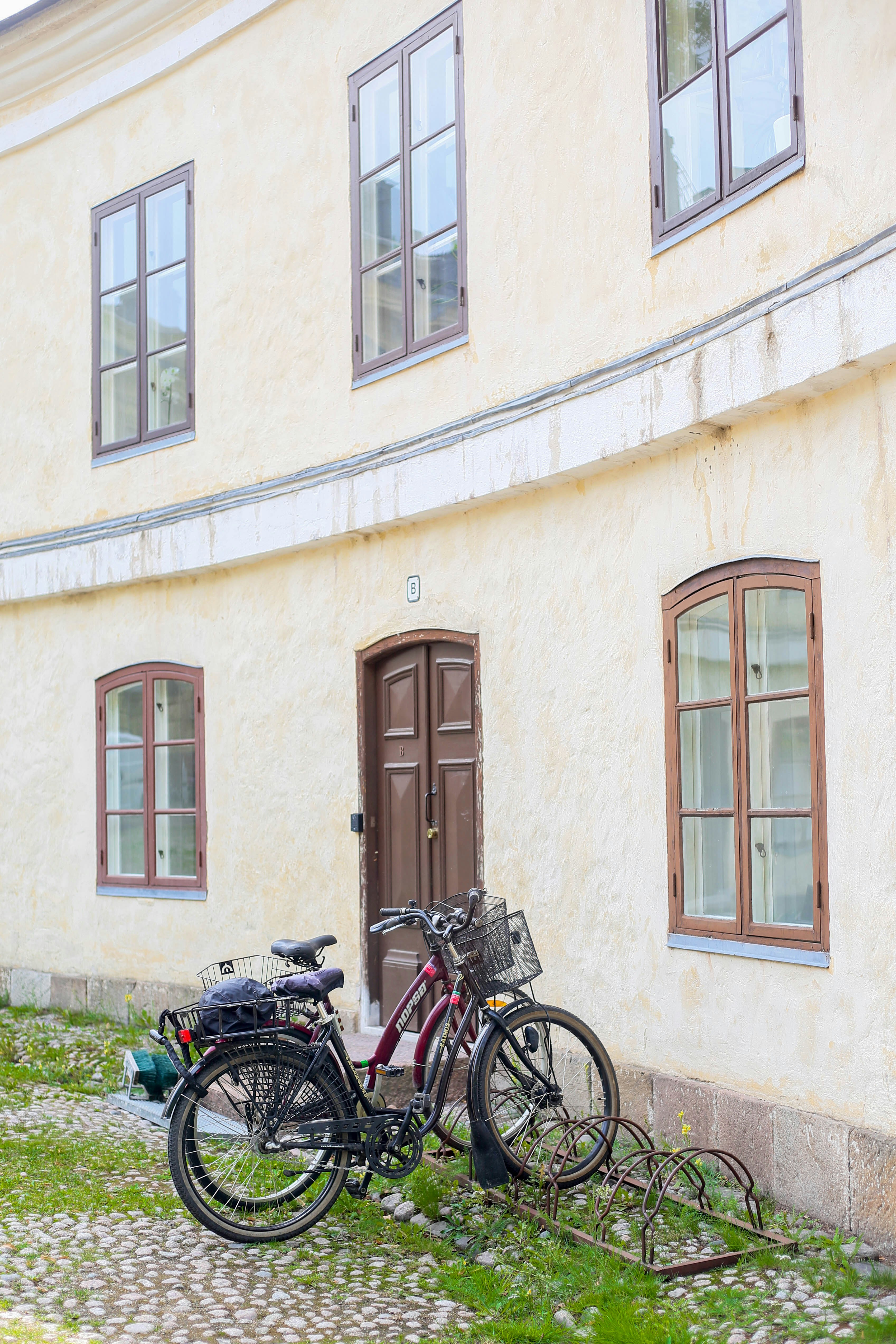 Pastel Facade, Tranquil Bicycles: A Cobblestone Street Portrait