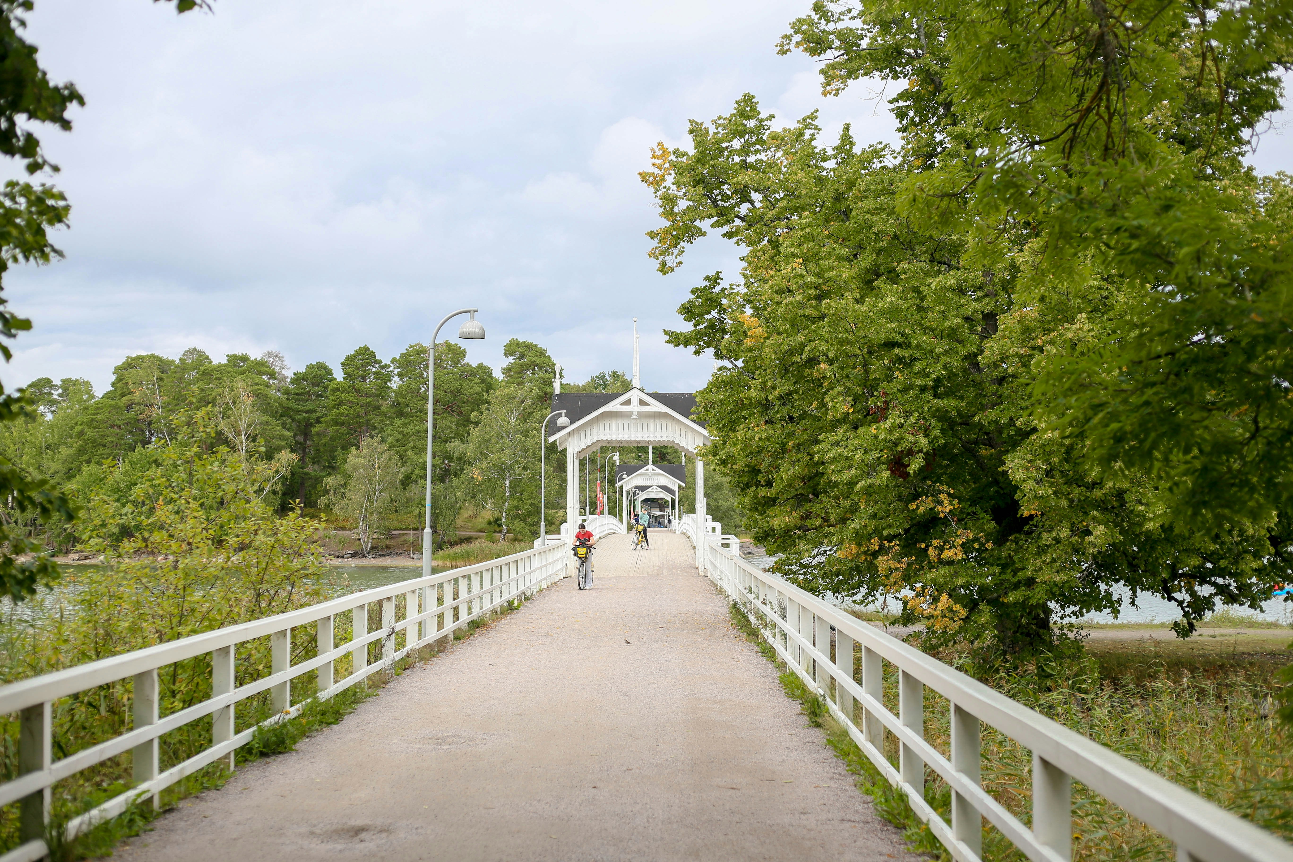 long road | White bridge with people cycling in a park
