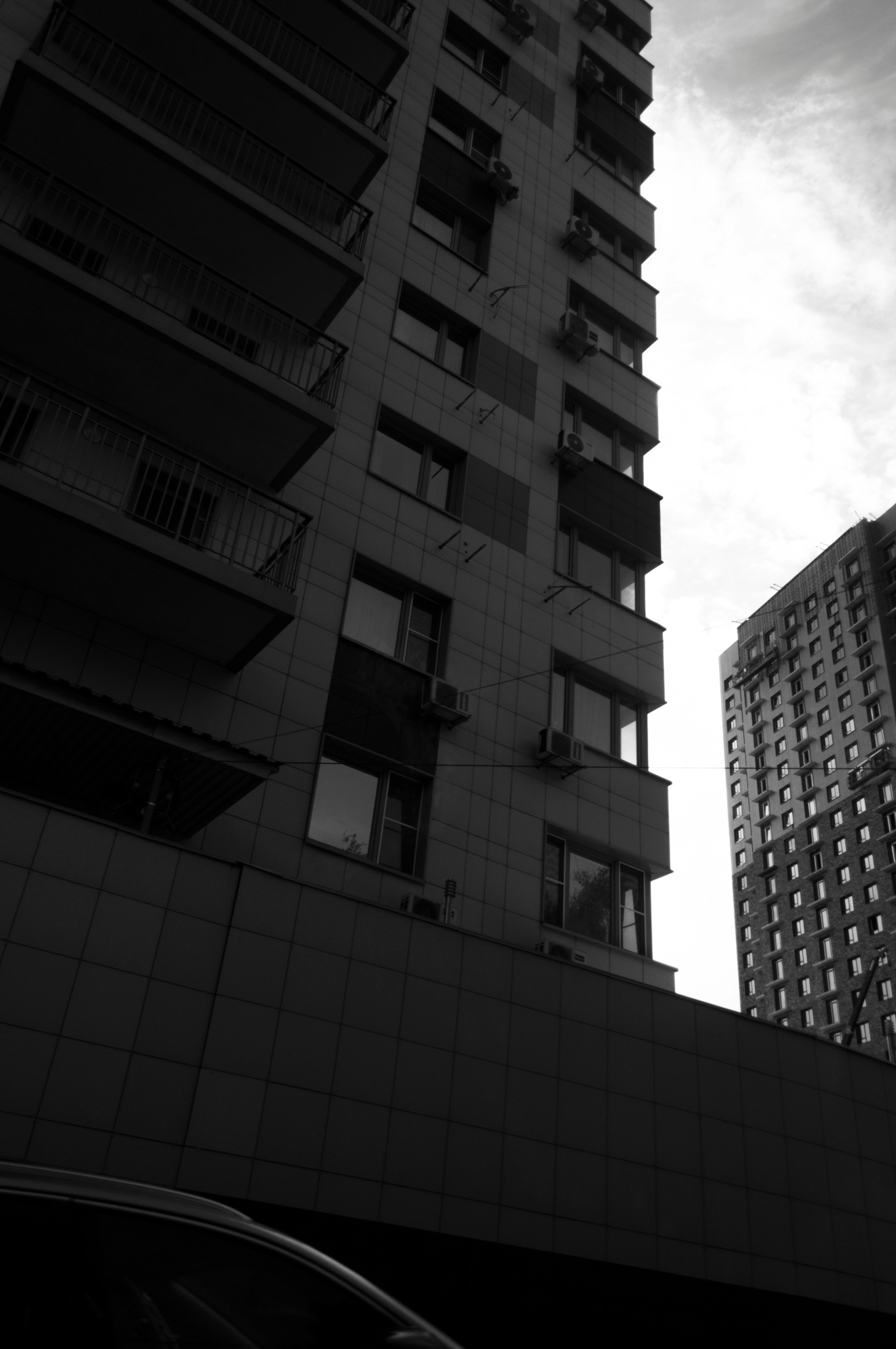 Tall apartment buildings against a bright sky.