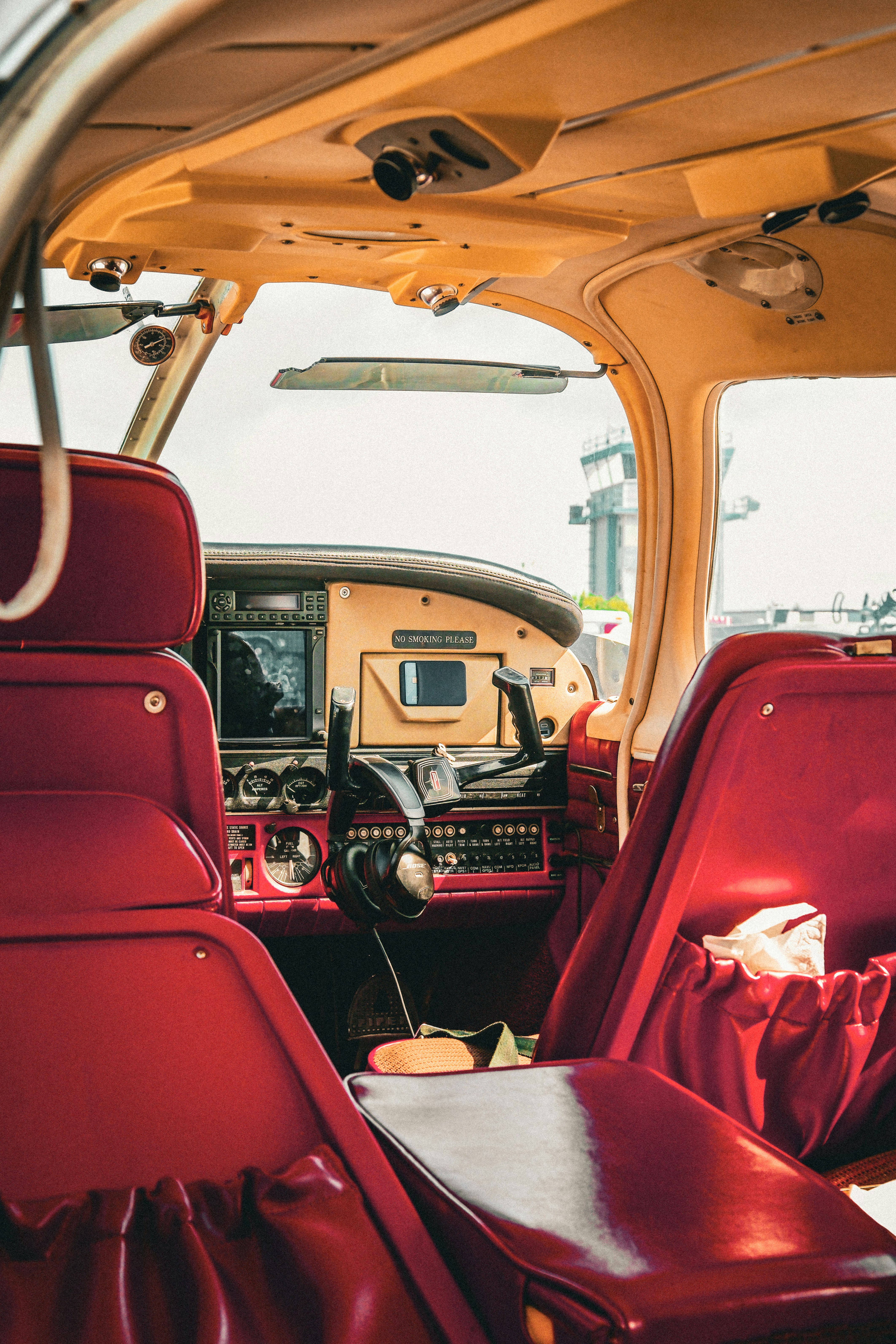 Interior view of a vintage airplane cockpit with red seats.