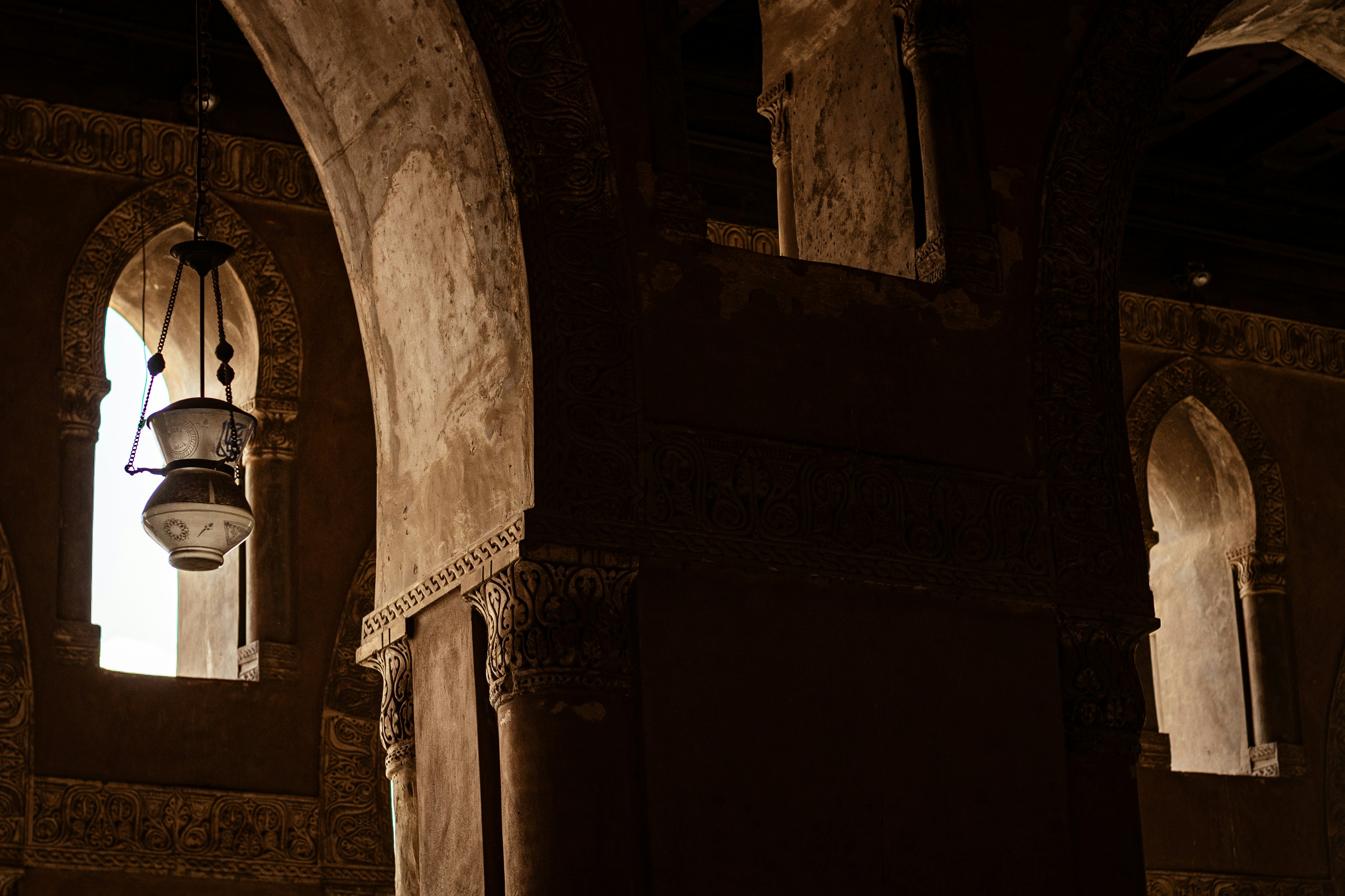 Interior of an old building with arched windows.