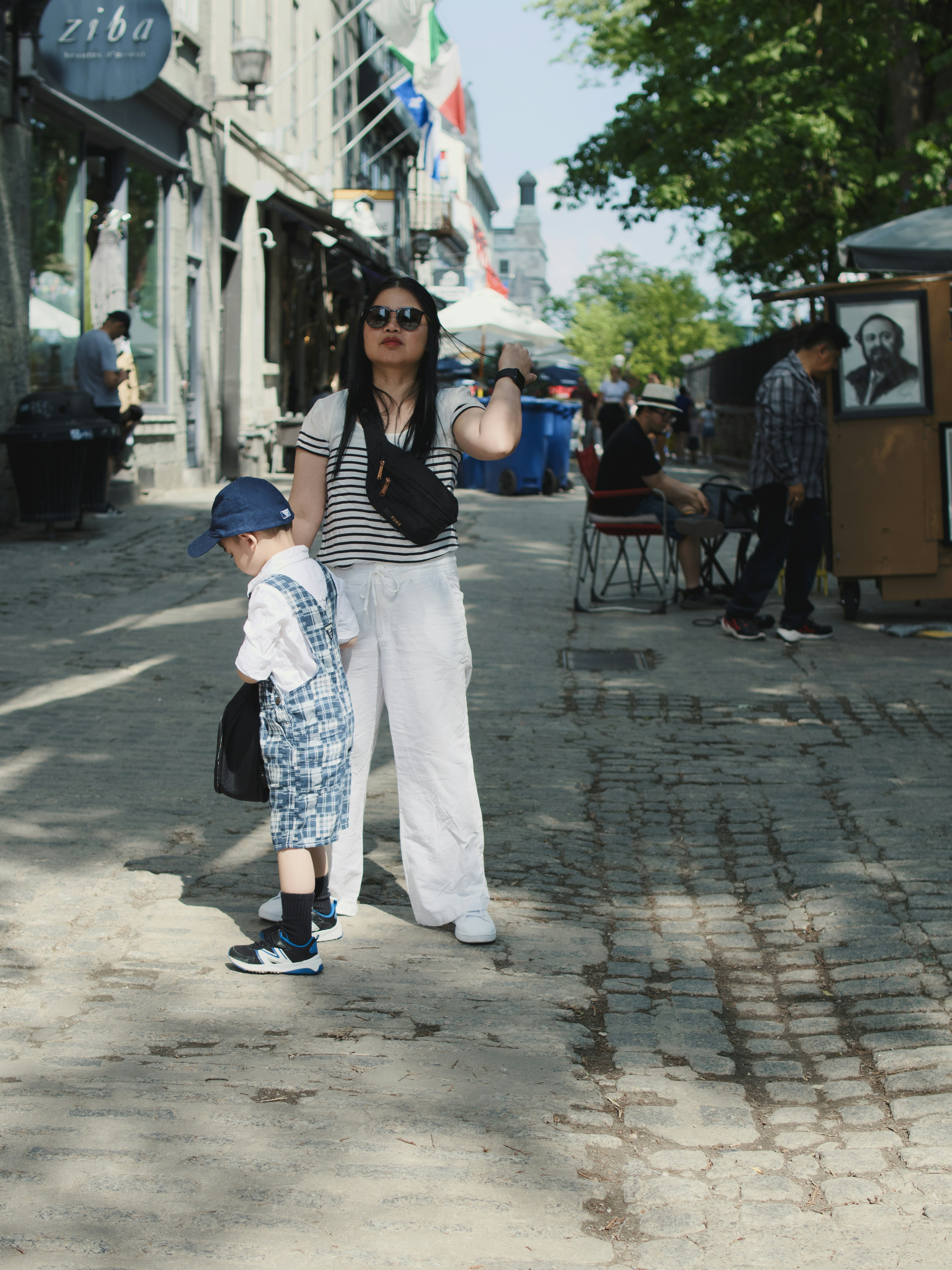 Woman and child walking on cobblestone street