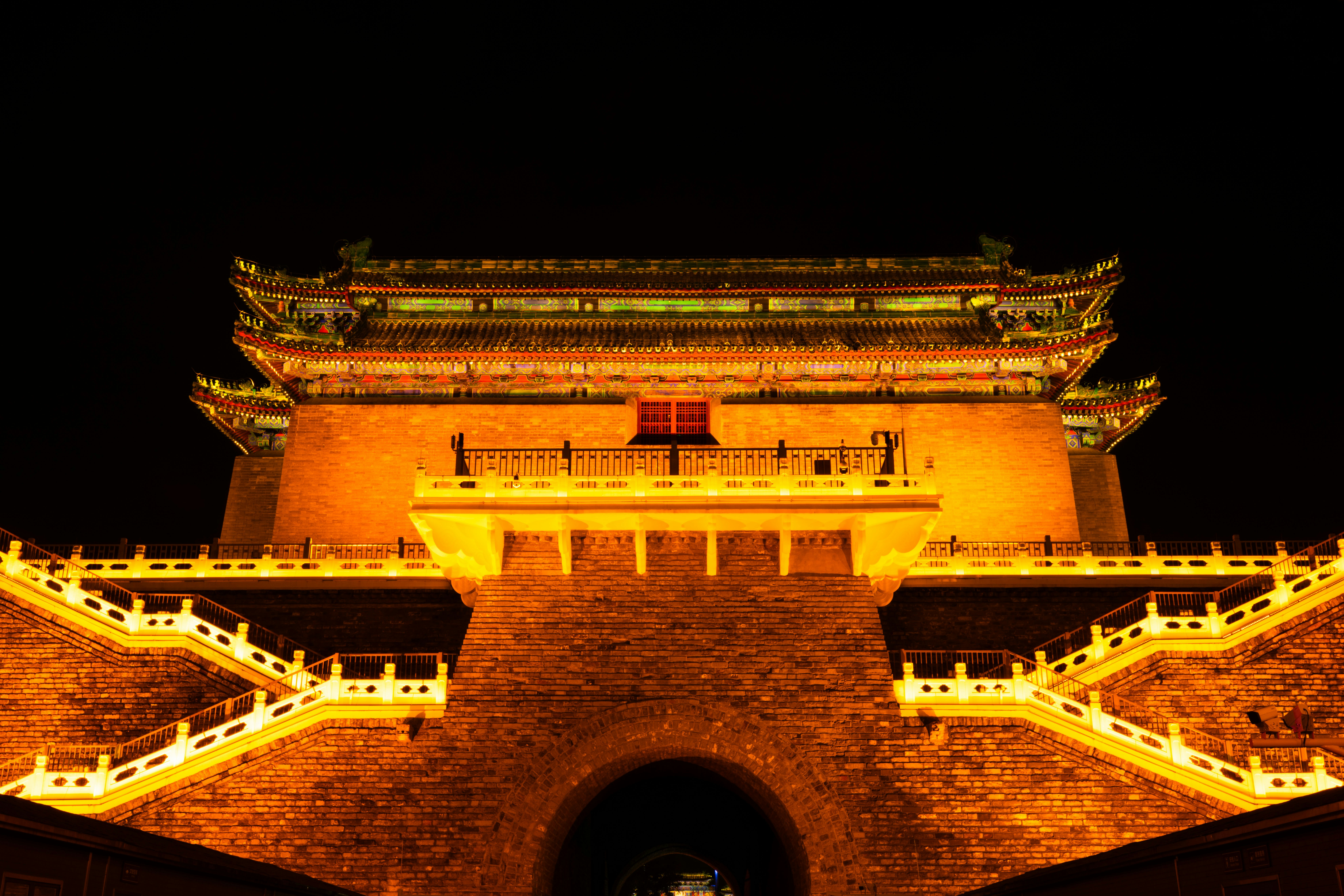 Historic illuminated gate at night with grand staircases