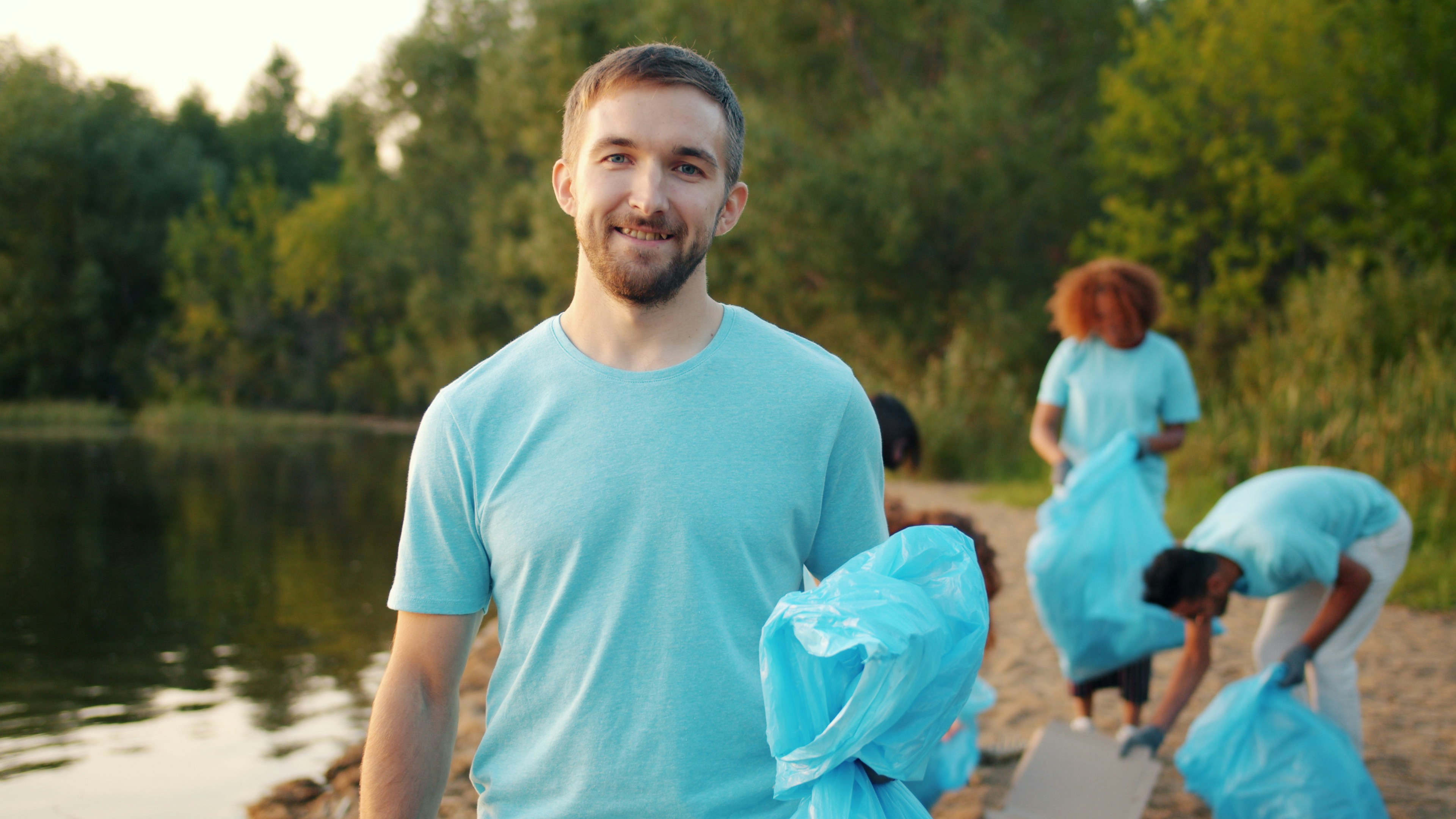 Man with trash bags near people cleaning outdoors photo – Free Beach ...