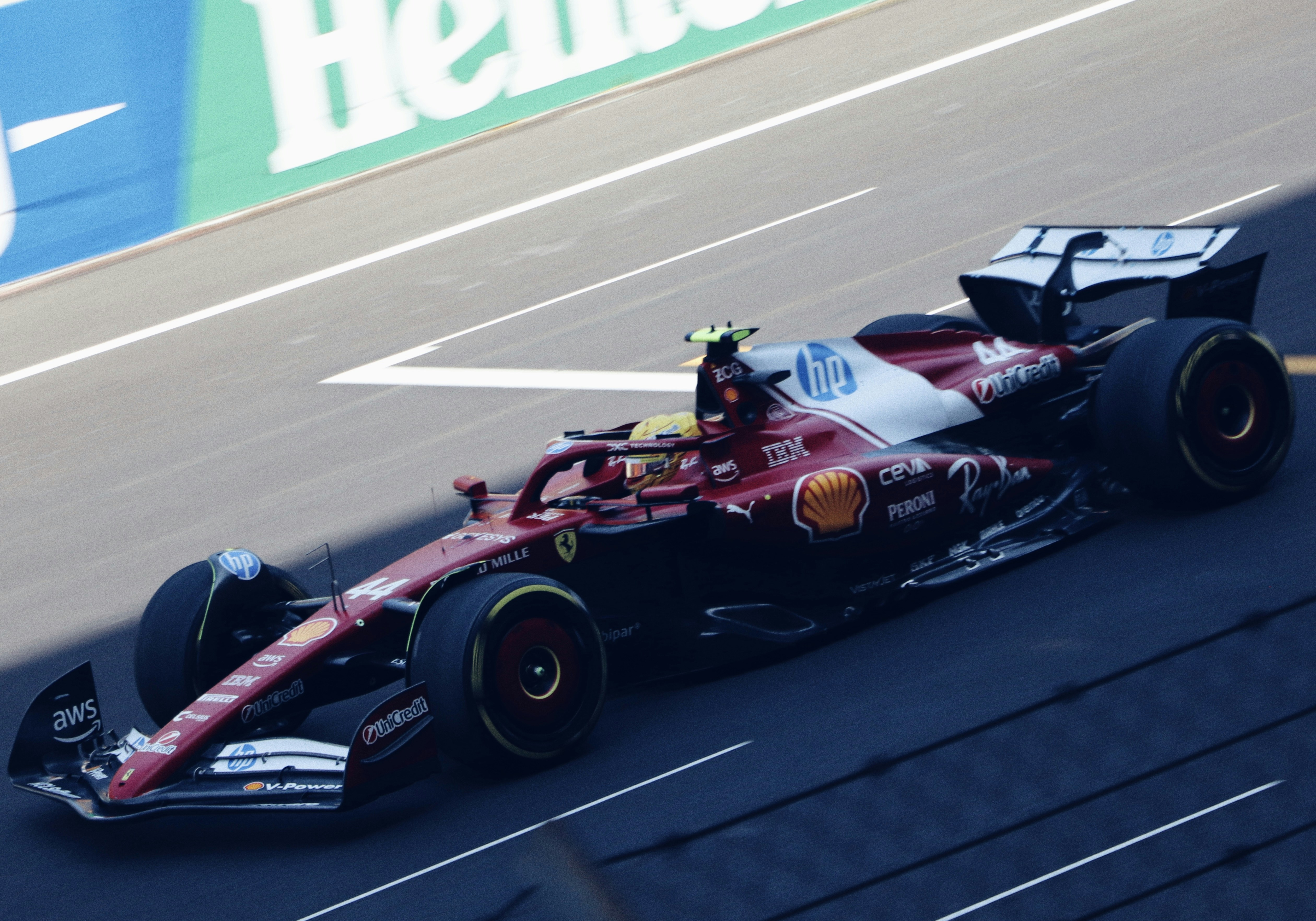 Ferrari Formula 1 car speeding down the track, showcasing its aerodynamic design and vibrant colors. The scene captures the thrill of motorsport in action.