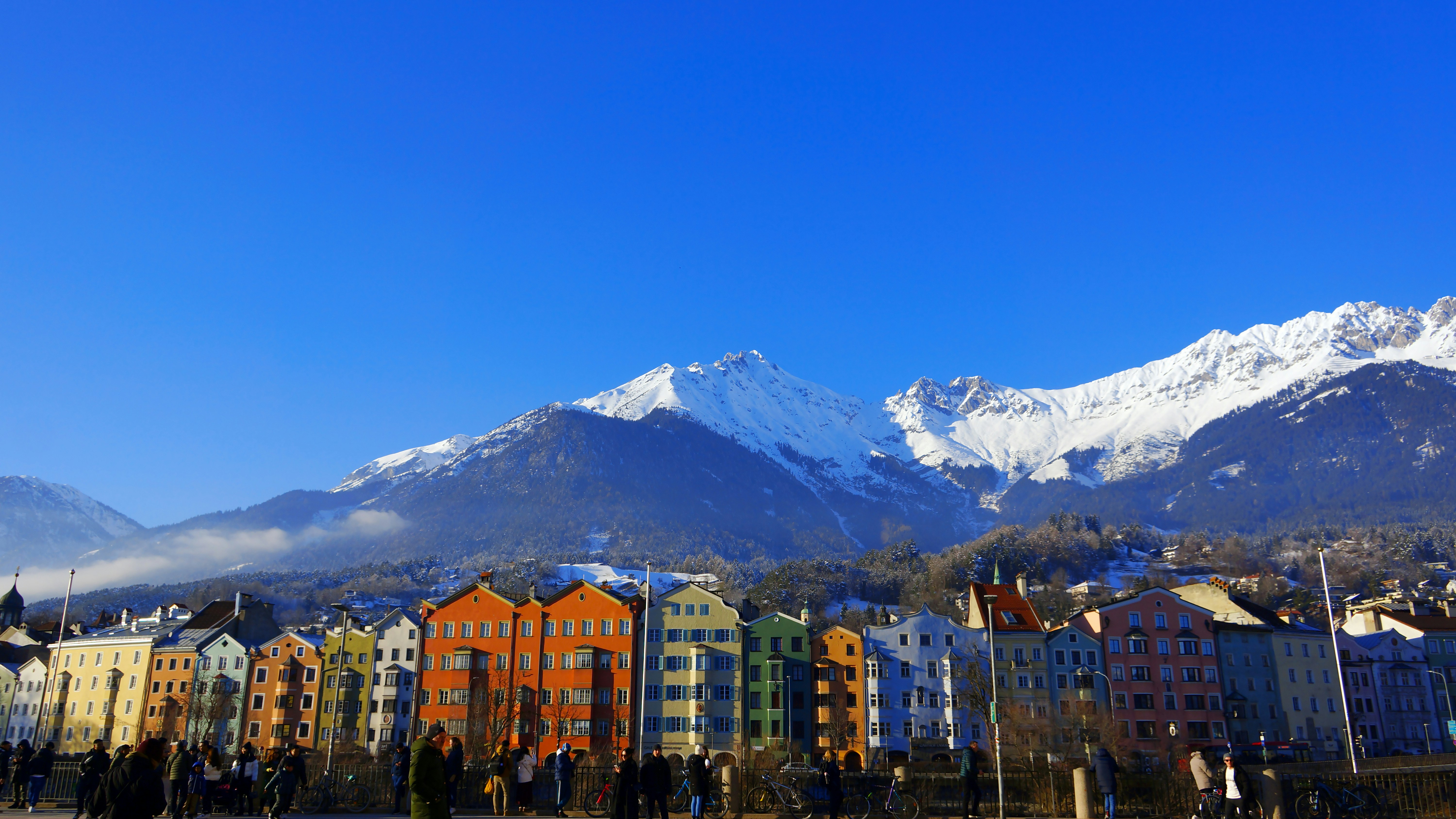 Colorful buildings with snow-capped mountains in background.