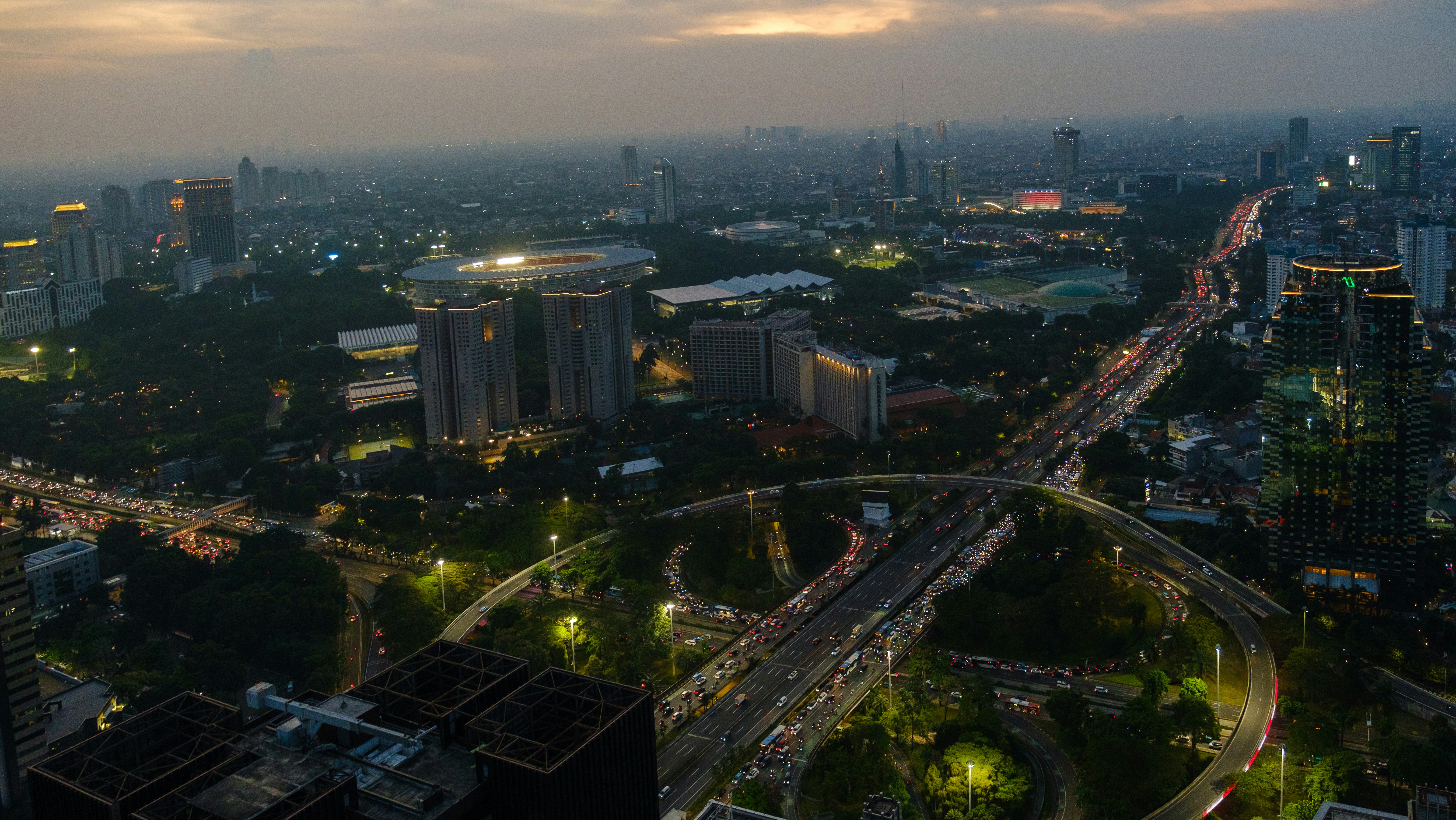 Busy city highway interchange at dusk with lights.