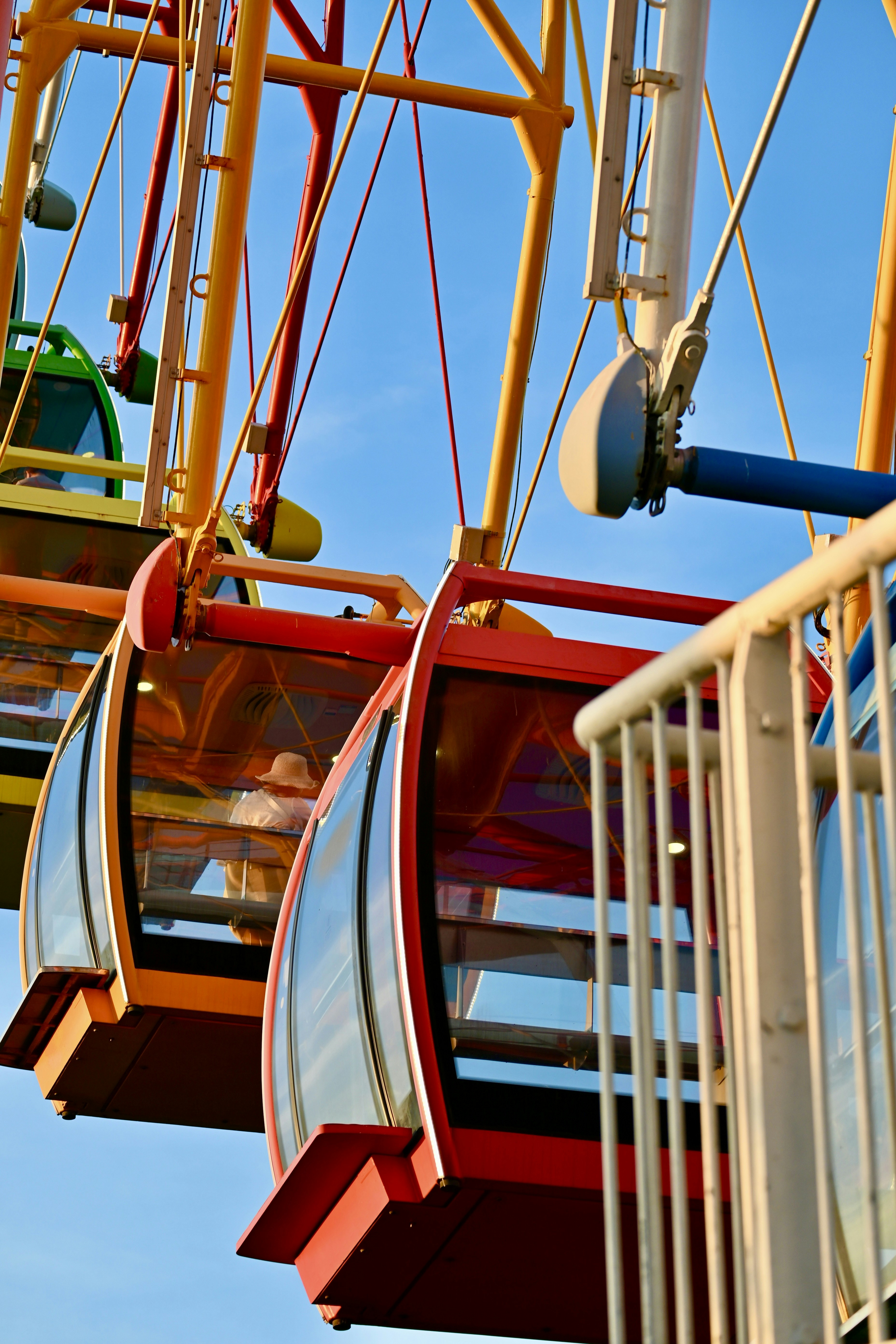 Colorful ferris wheel cabins against a blue sky
