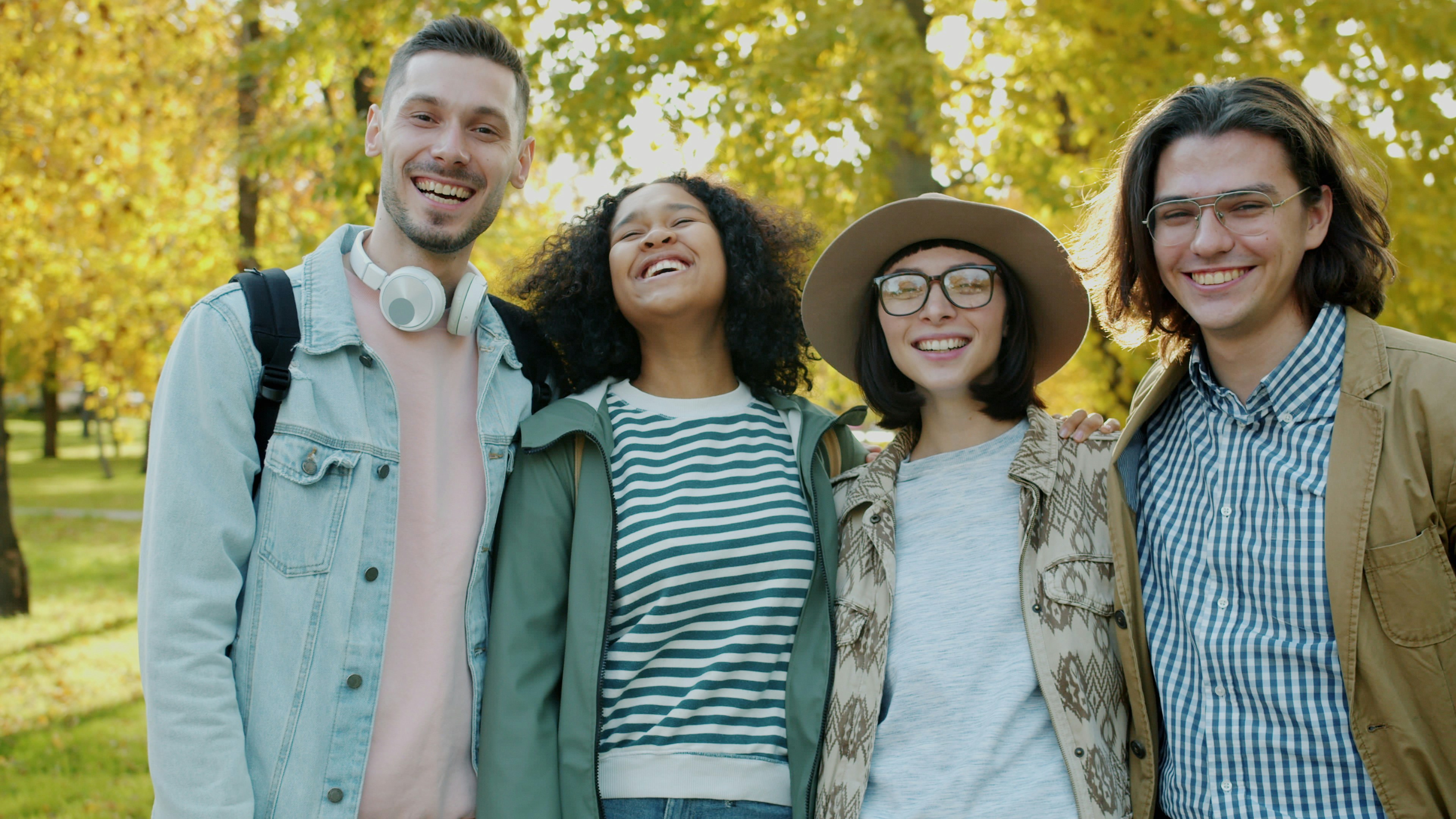 Four smiling friends posing together outdoors in autumn. photo – Free ...