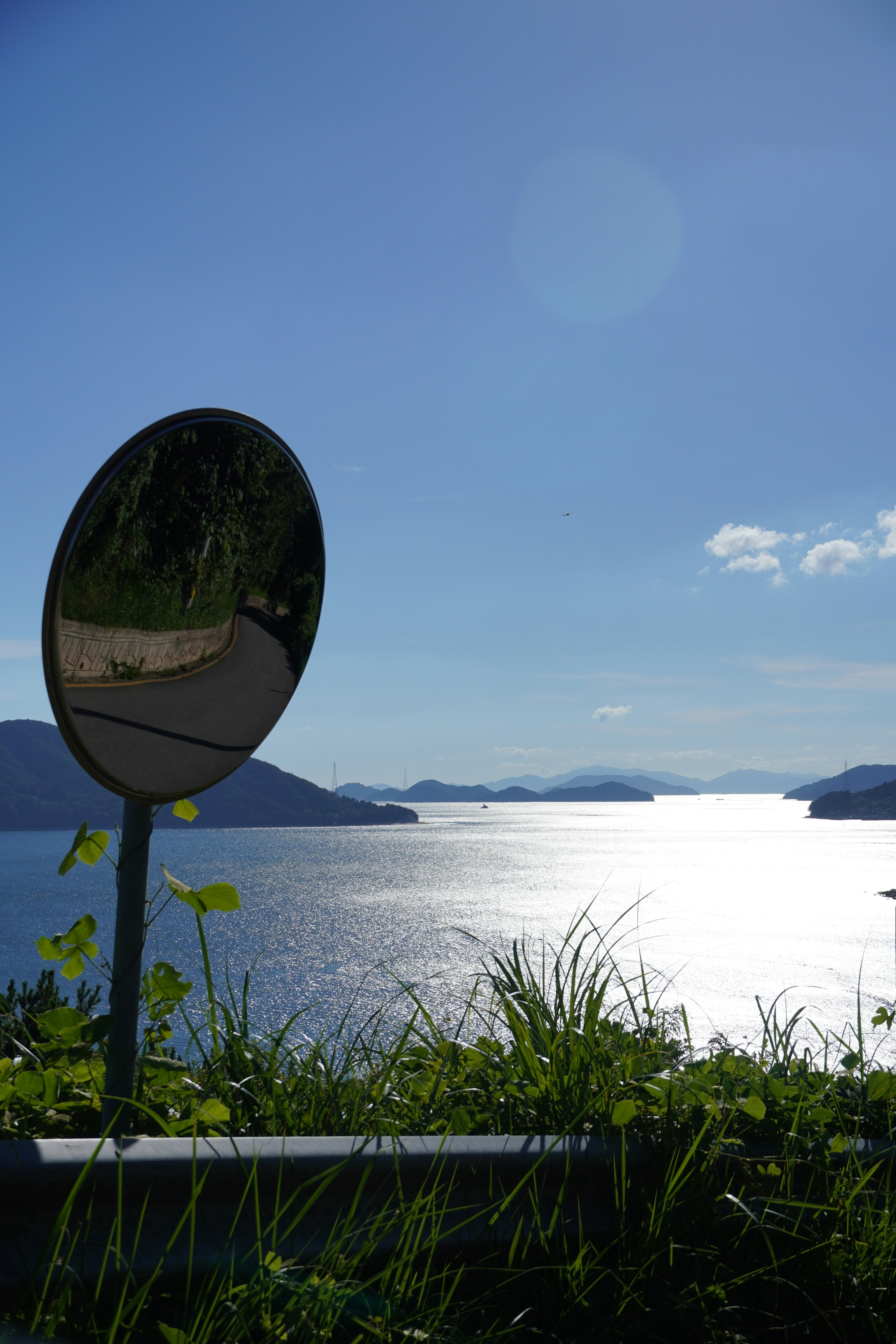 Round Witness: A Convex Mirror Framing a Sunlit Coastal View