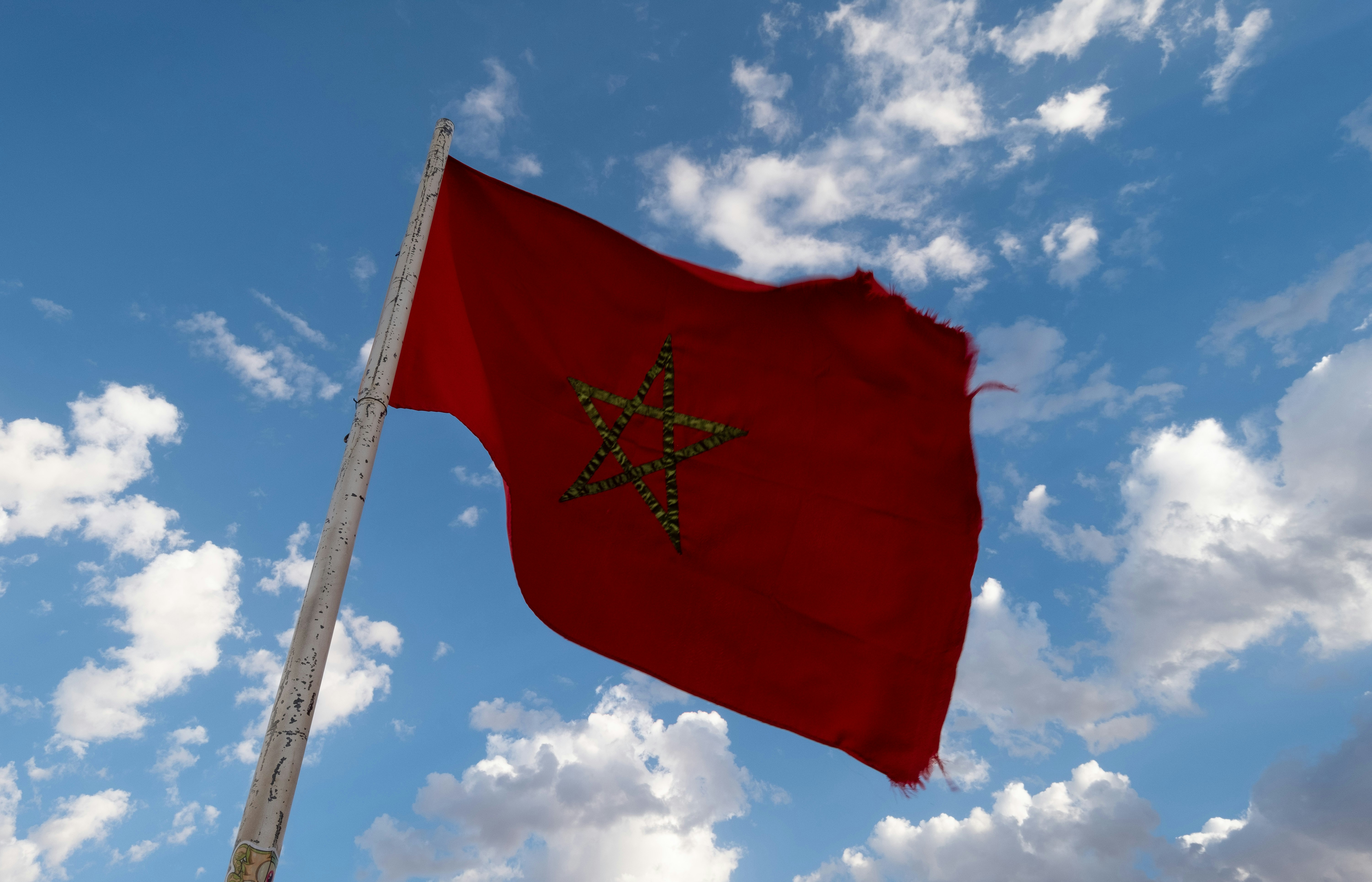 Red flag with green star against blue sky