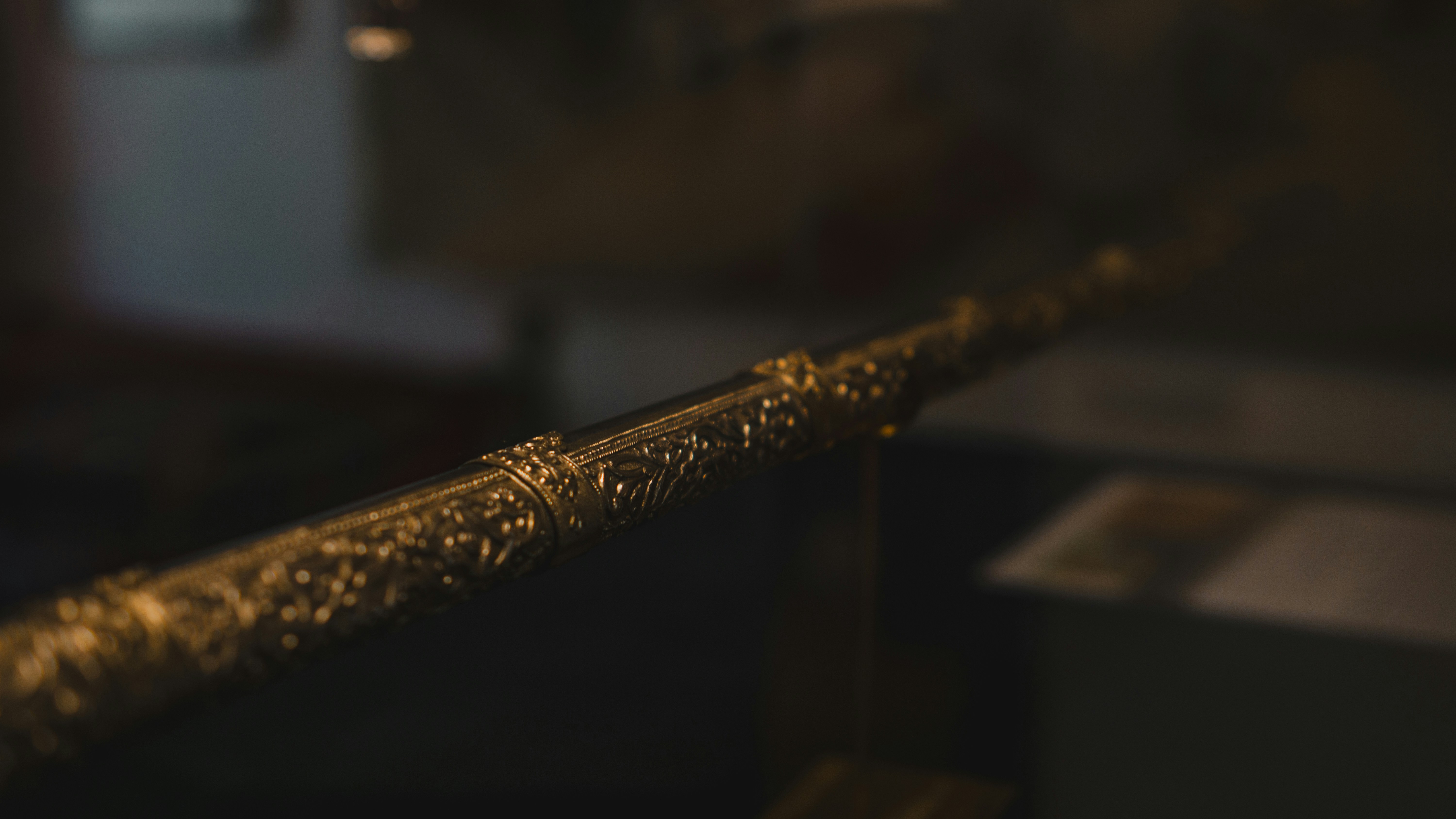 Close up of a golden ornate wand with small crystals.