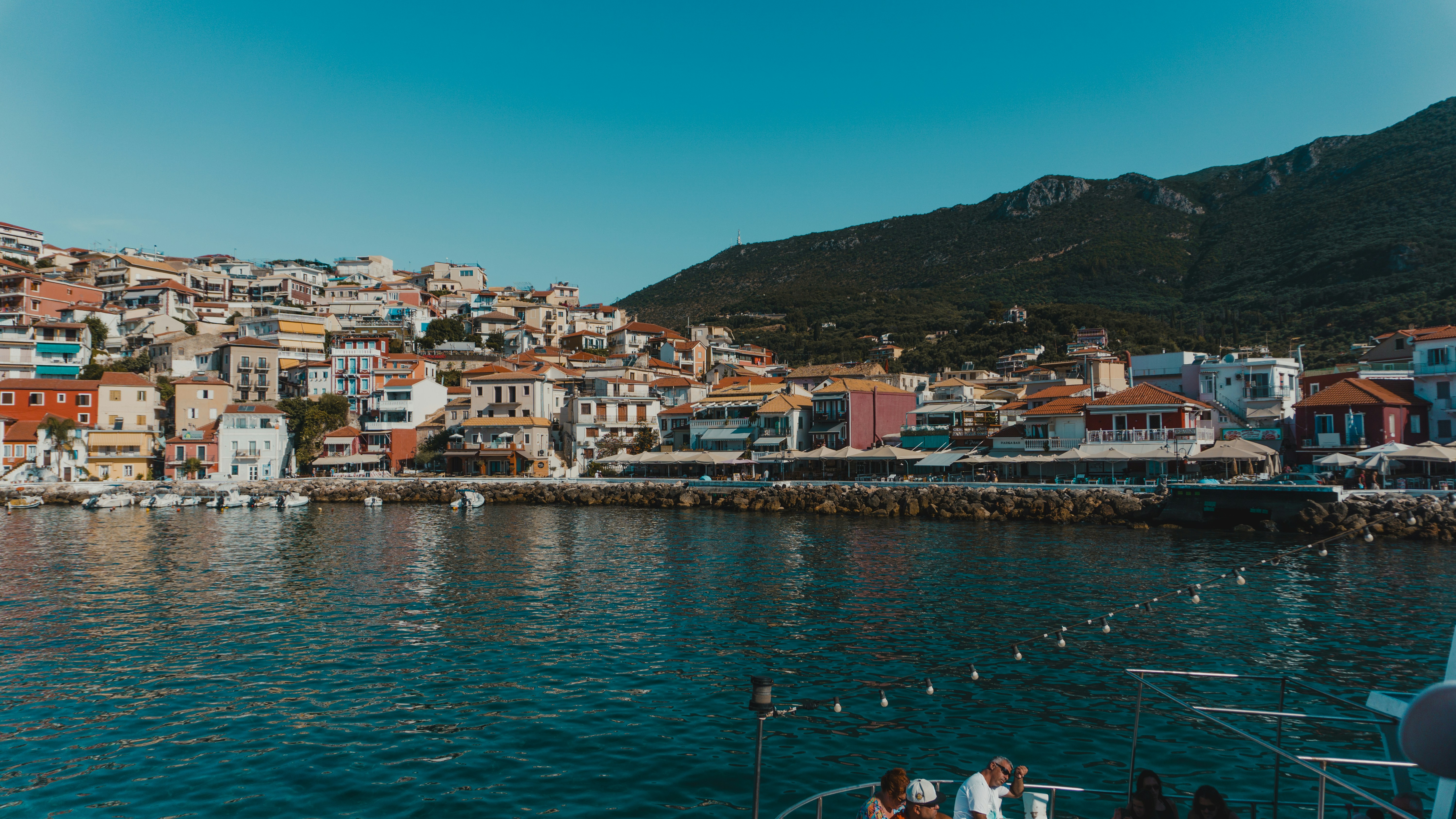Colorful buildings line a harbor with a mountain backdrop.