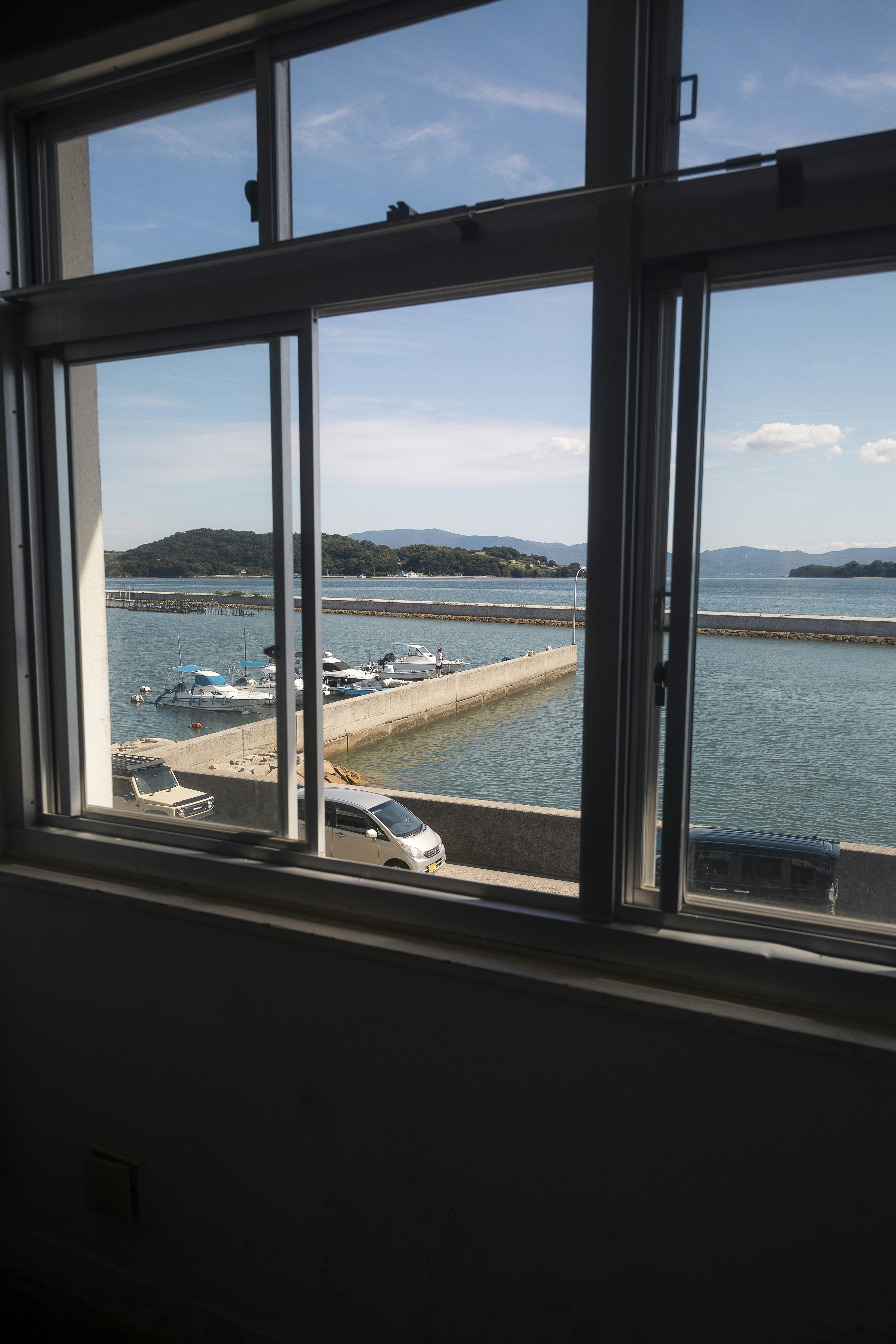 Boats docked at a pier seen through a window.