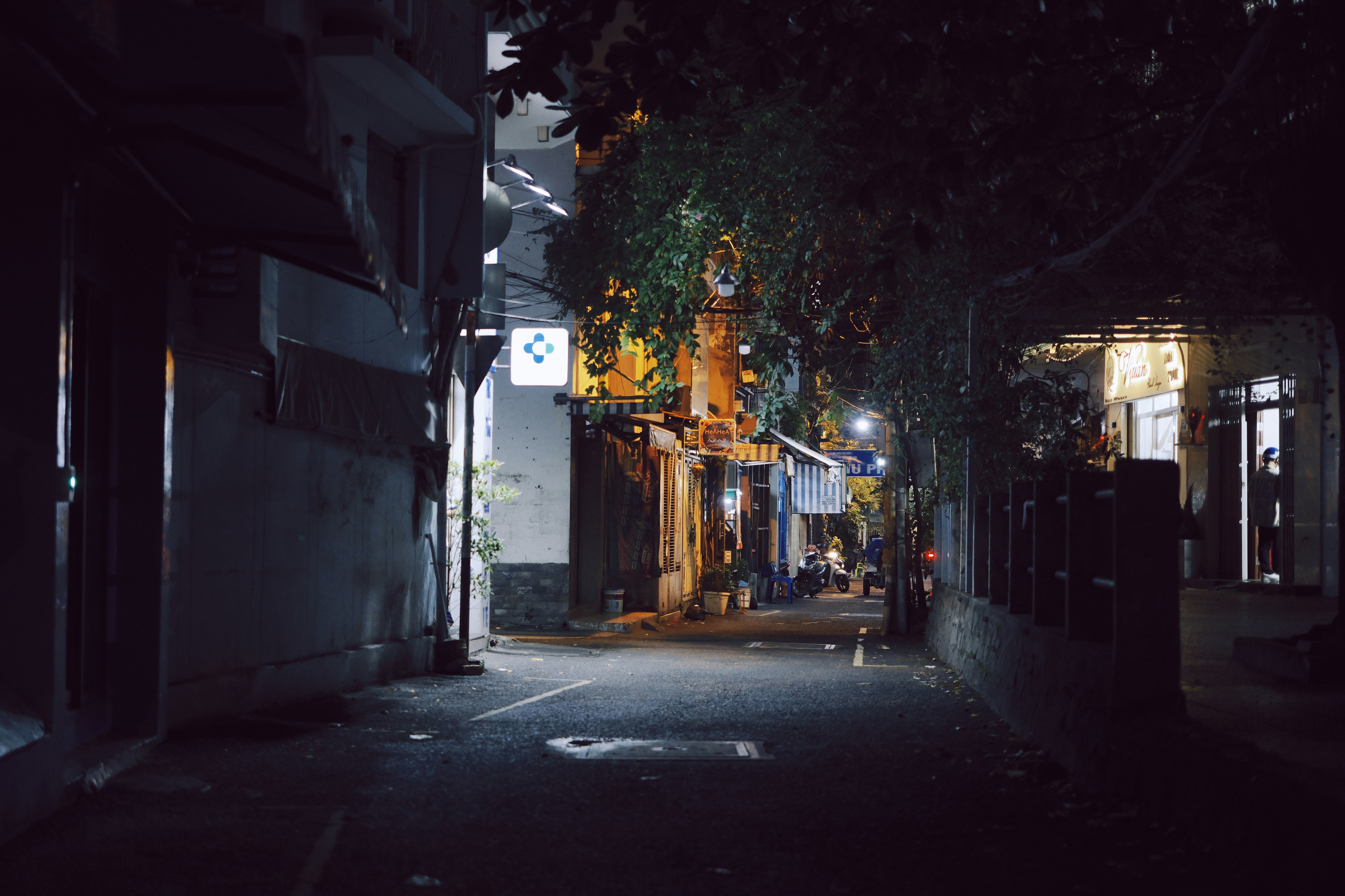 Dark alleyway at night with glowing lights.