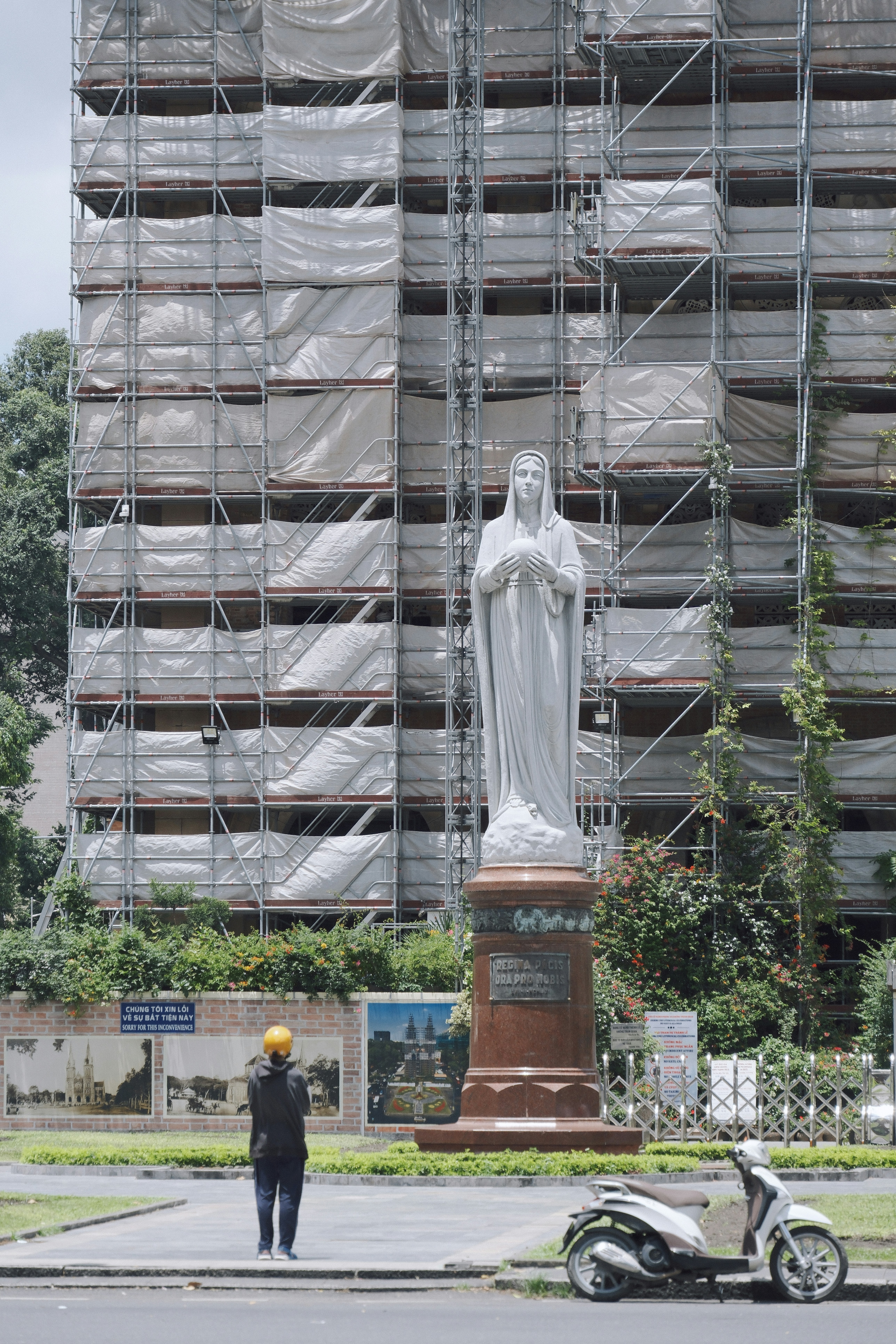 Statue of mary in front of building under construction