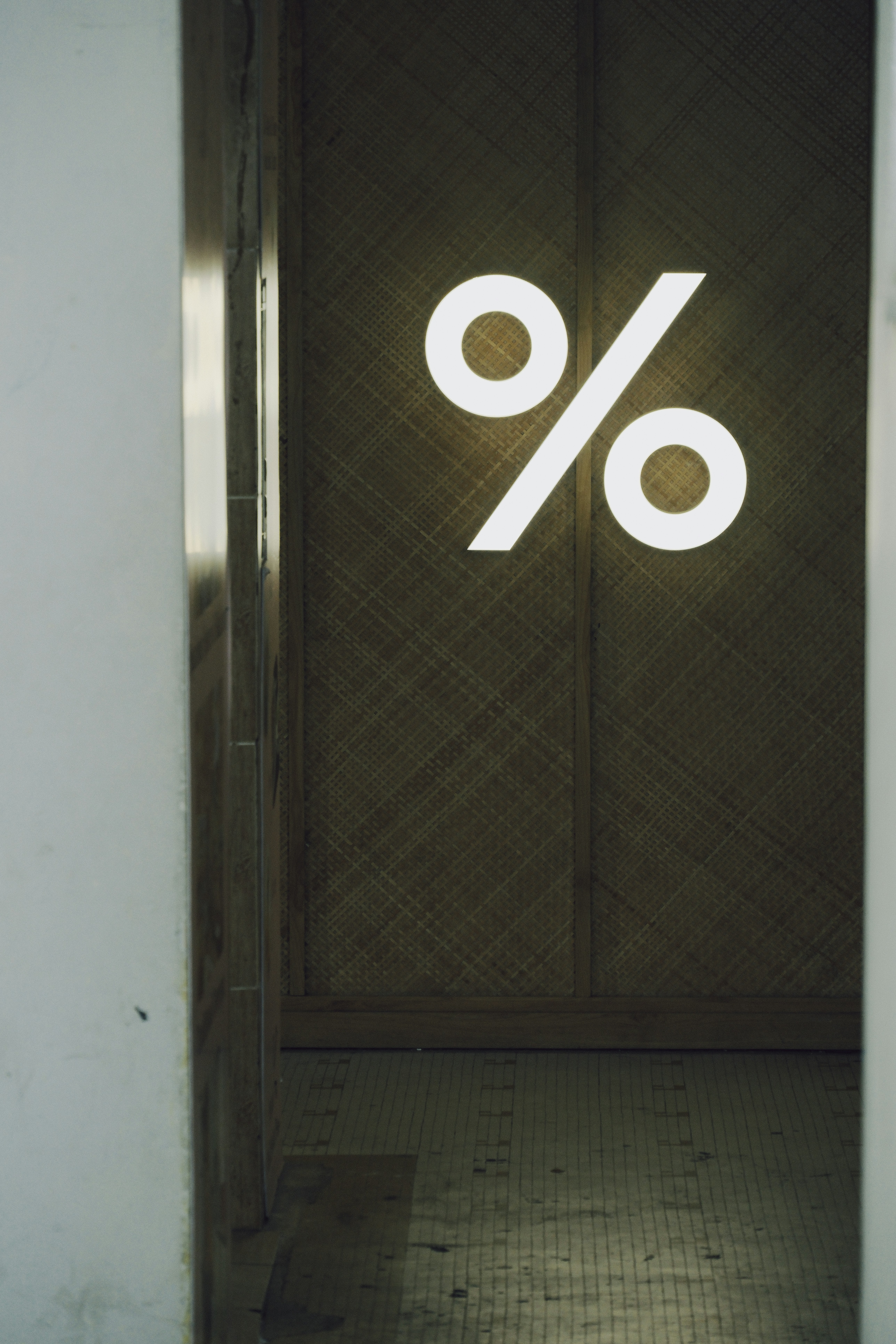 A glowing percent sign on a wooden door.