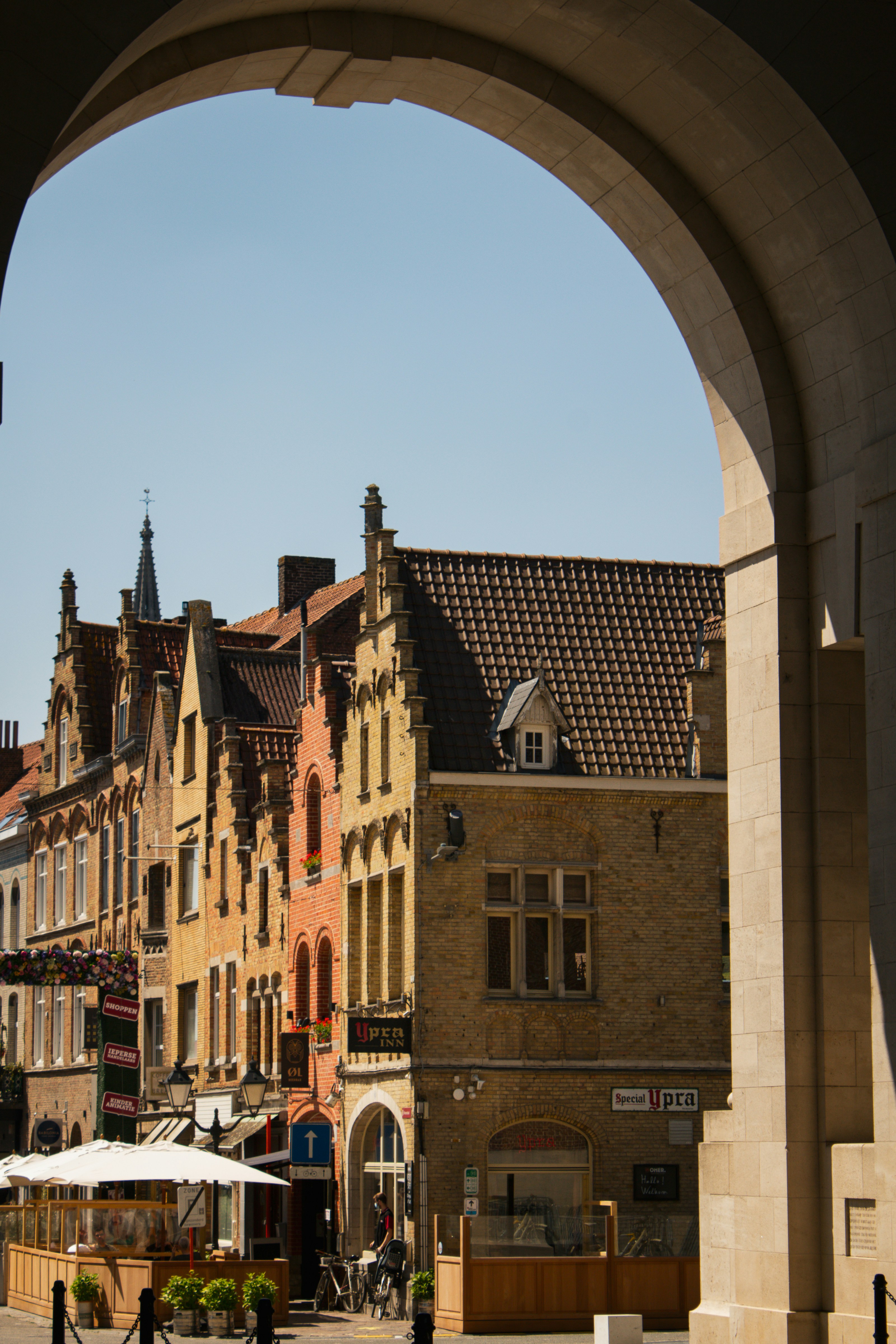Ornate buildings viewed through an archway on a sunny day.