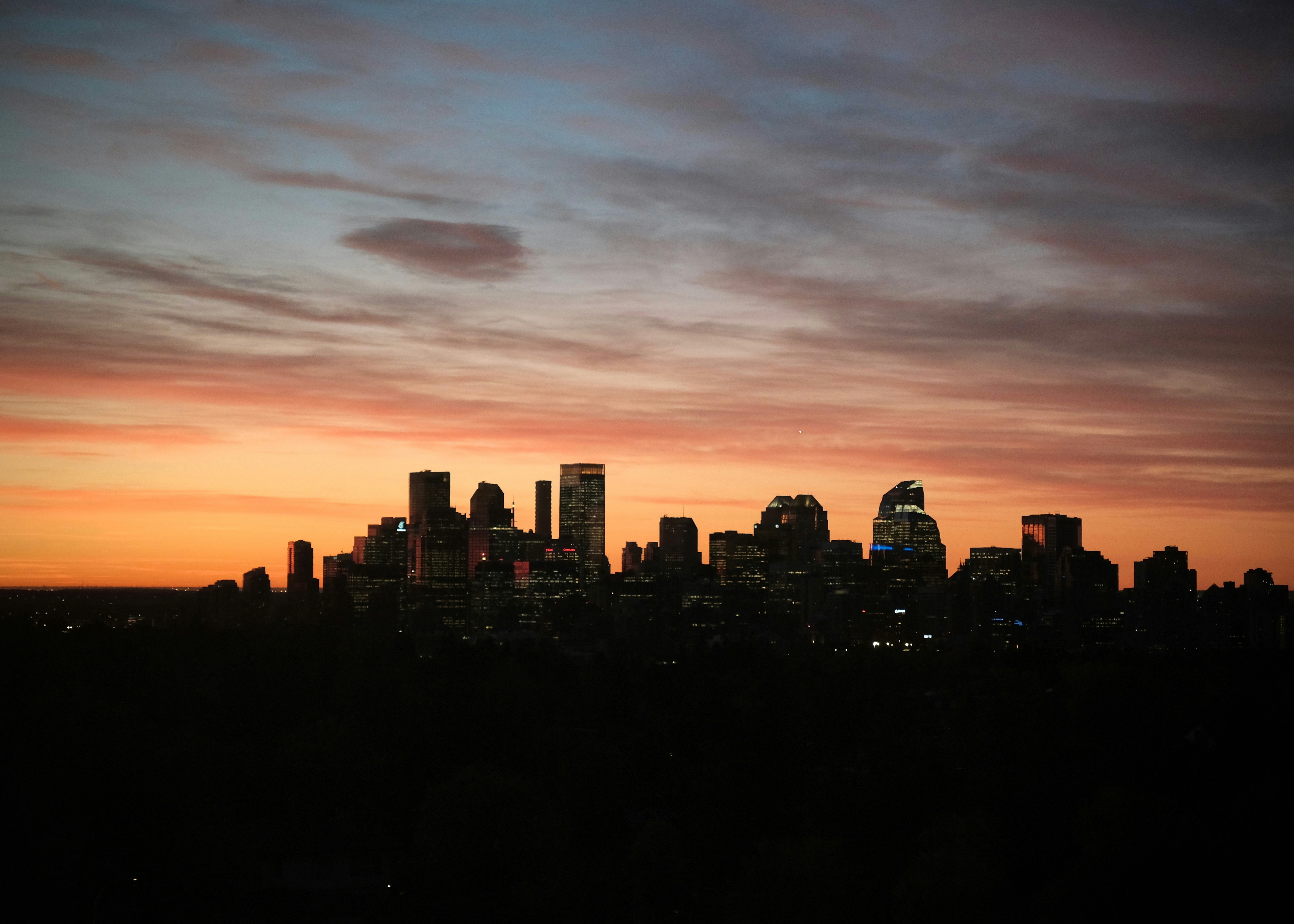 City skyline silhouette against a colorful sunset sky