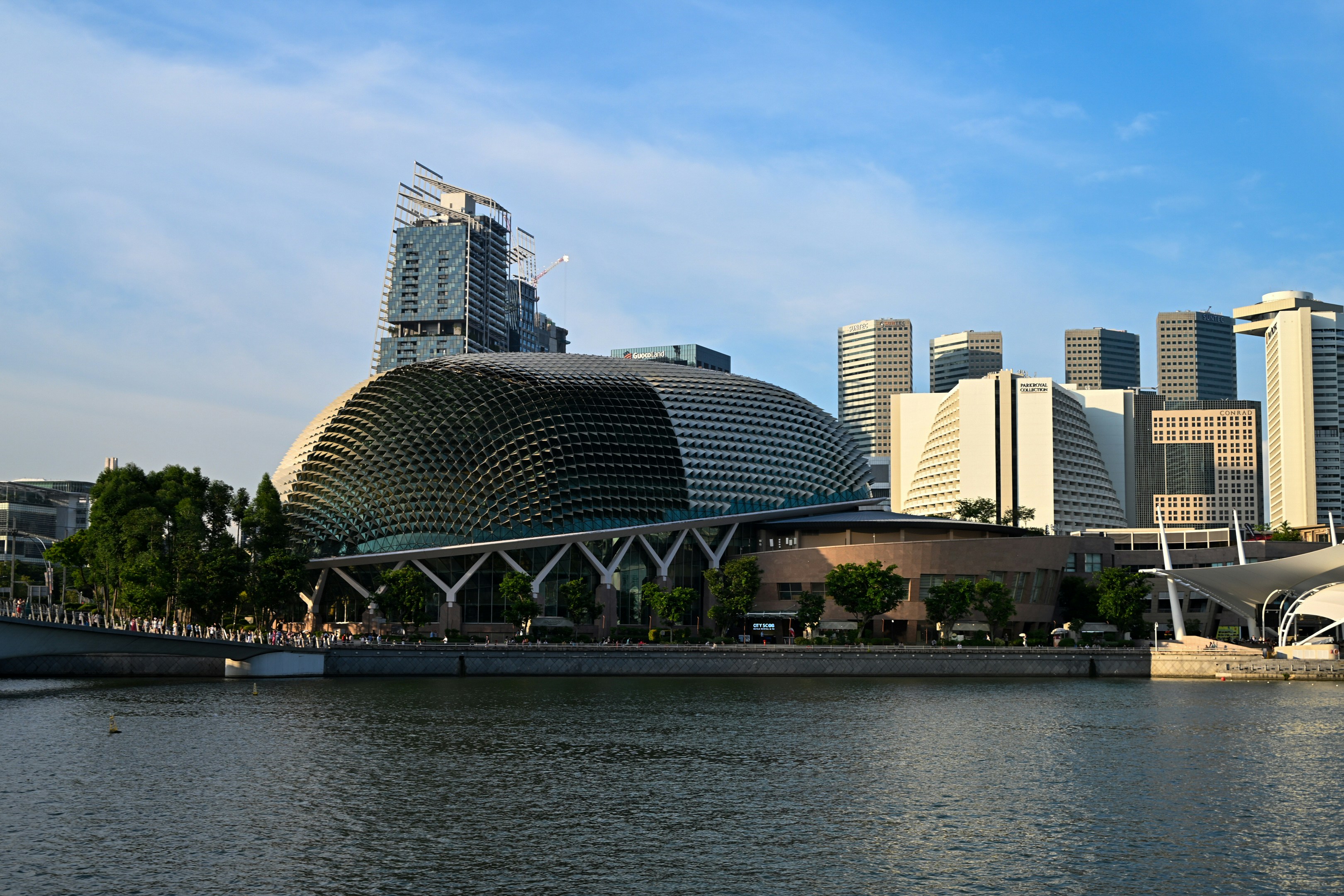 Modern waterfront buildings with a domed structure.
