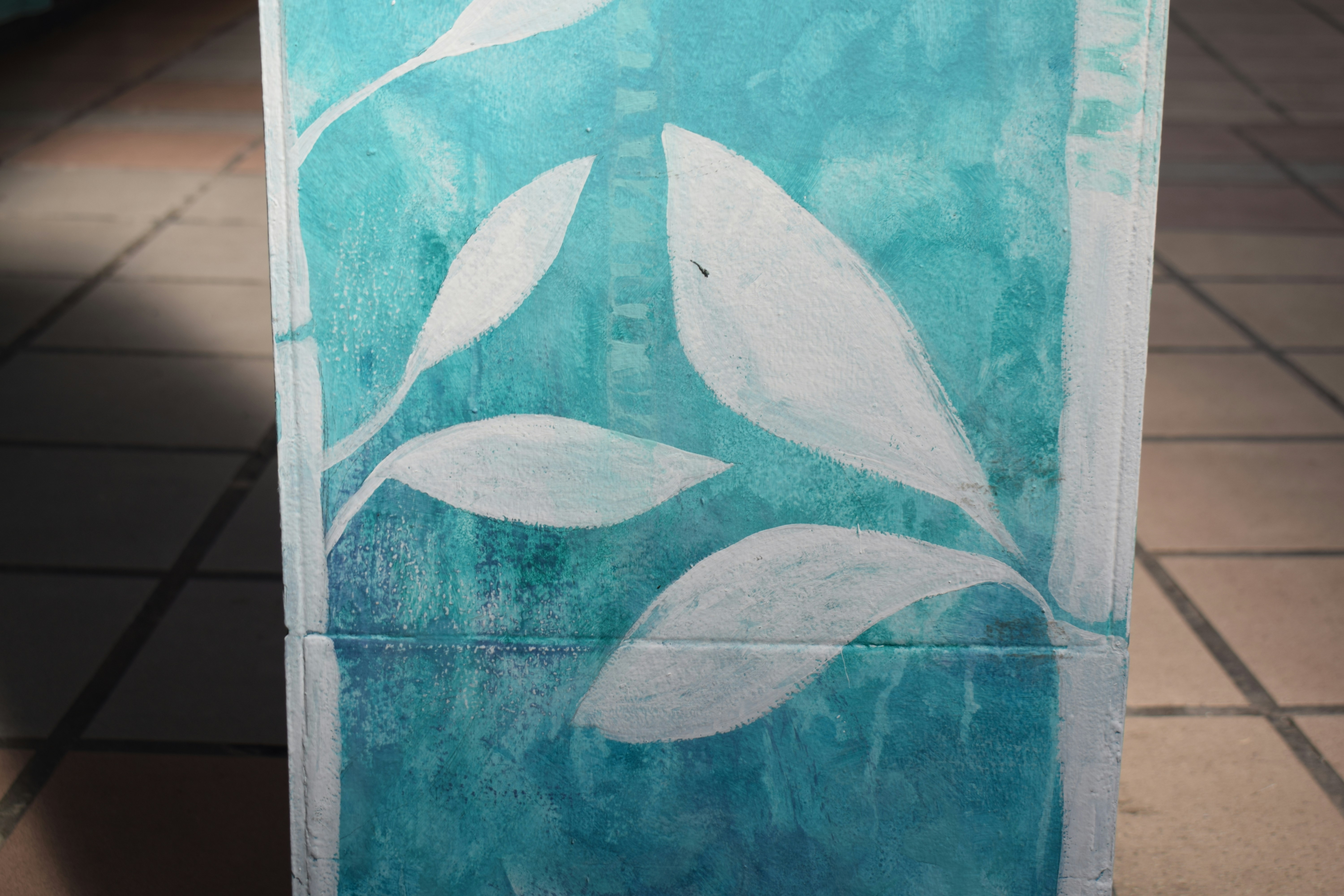 White leaves painted on a teal background