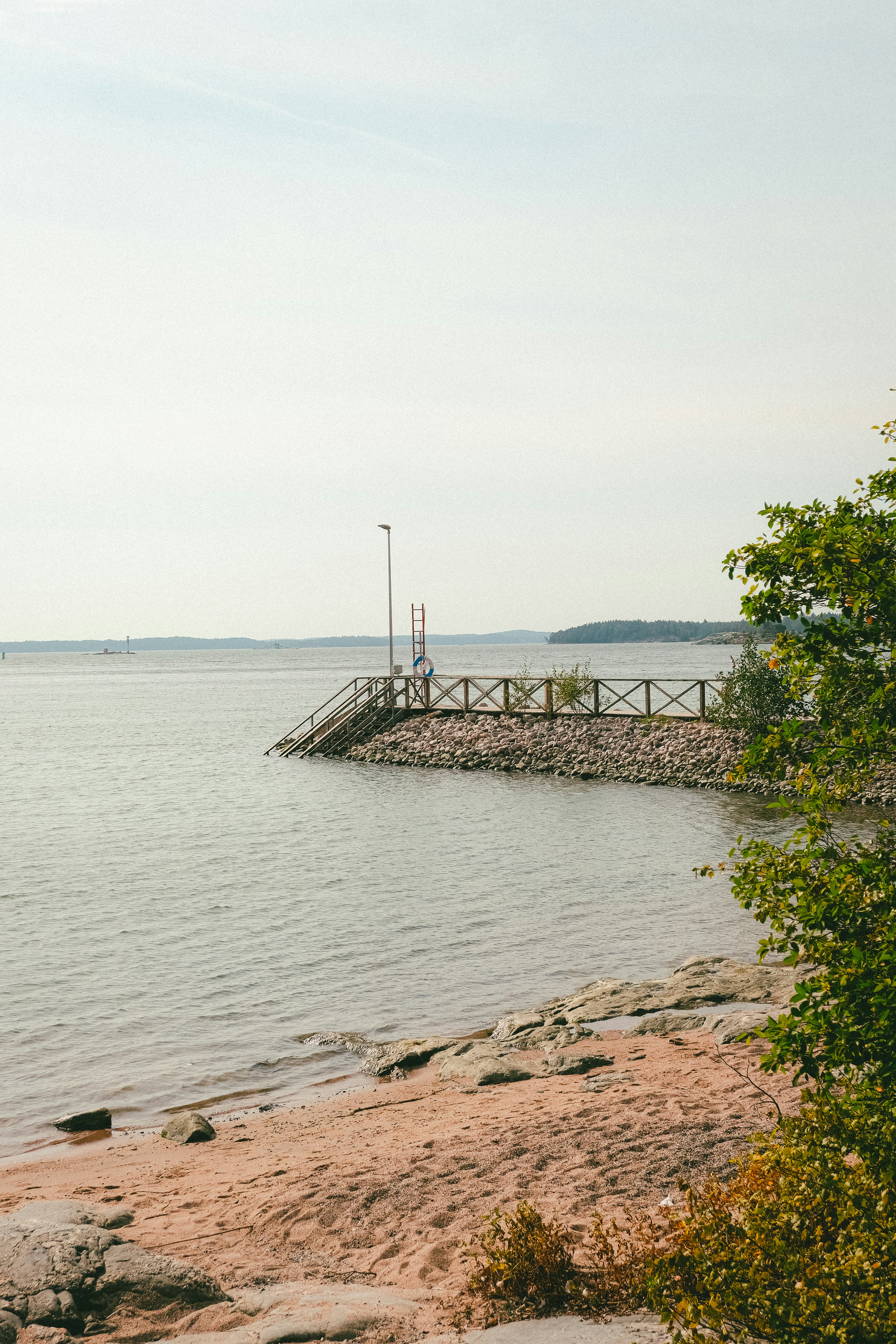 Ruissalo is a picturesque island located just southwest of Turku, Finland, and is easily accessible from the city. Known for its ancient oak forests—some of the largest in Finland—the island is celebrated as both a natural haven and a cultural treasure. | Wooden pier with steps on a rocky shore