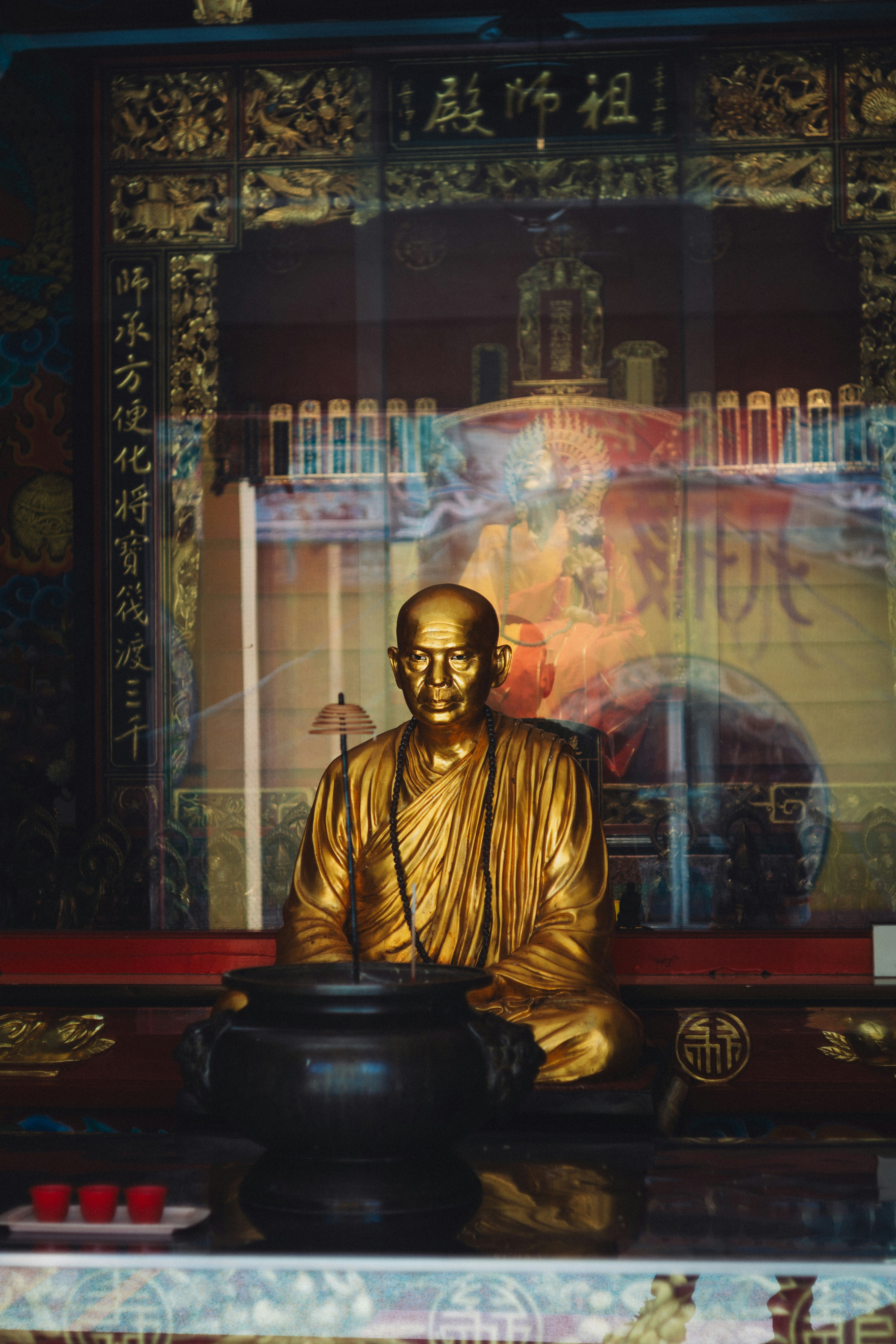 Golden statue of a seated monk in a temple.