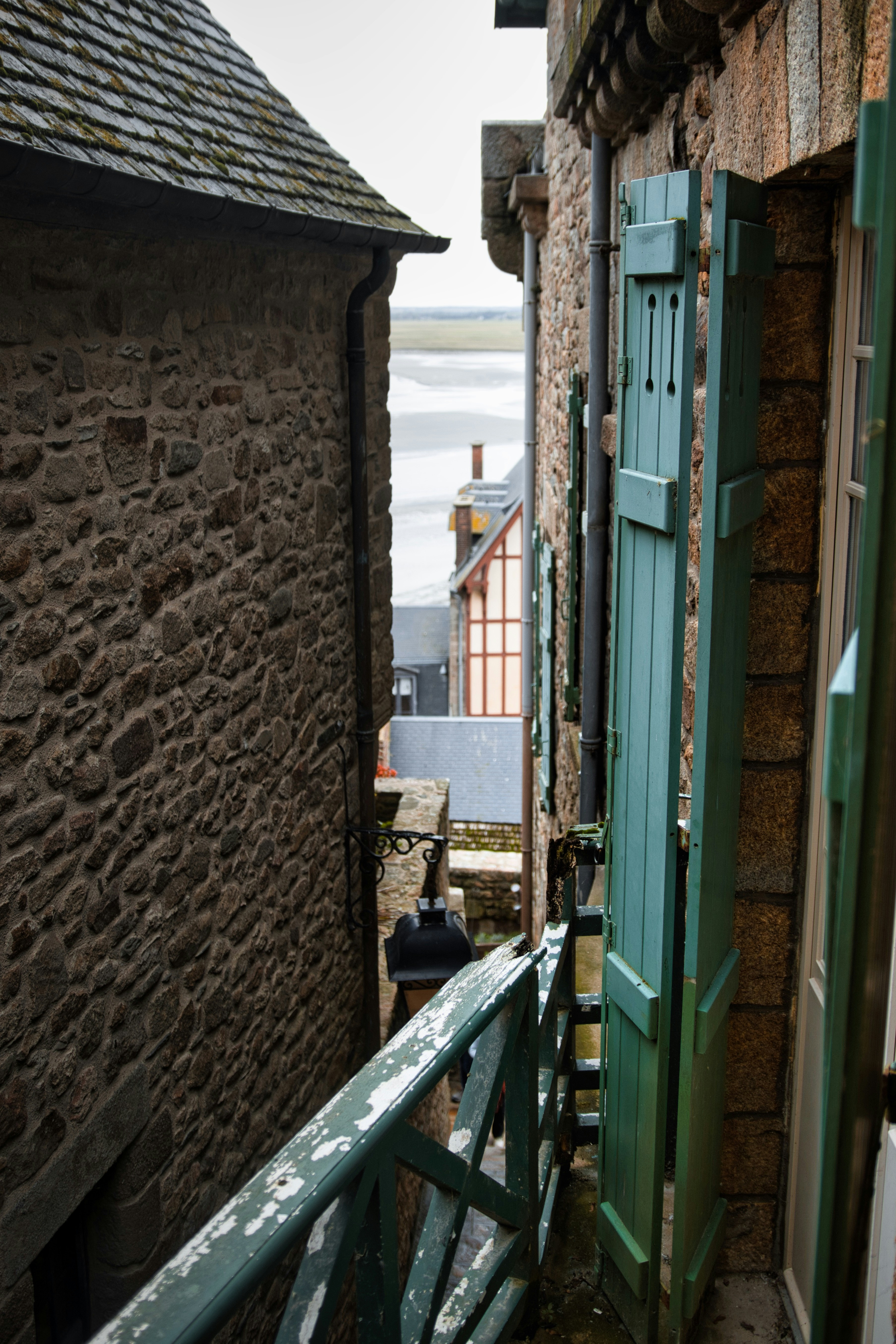 Teal Shutters and Stone Light: A Narrow Path to the Harbor