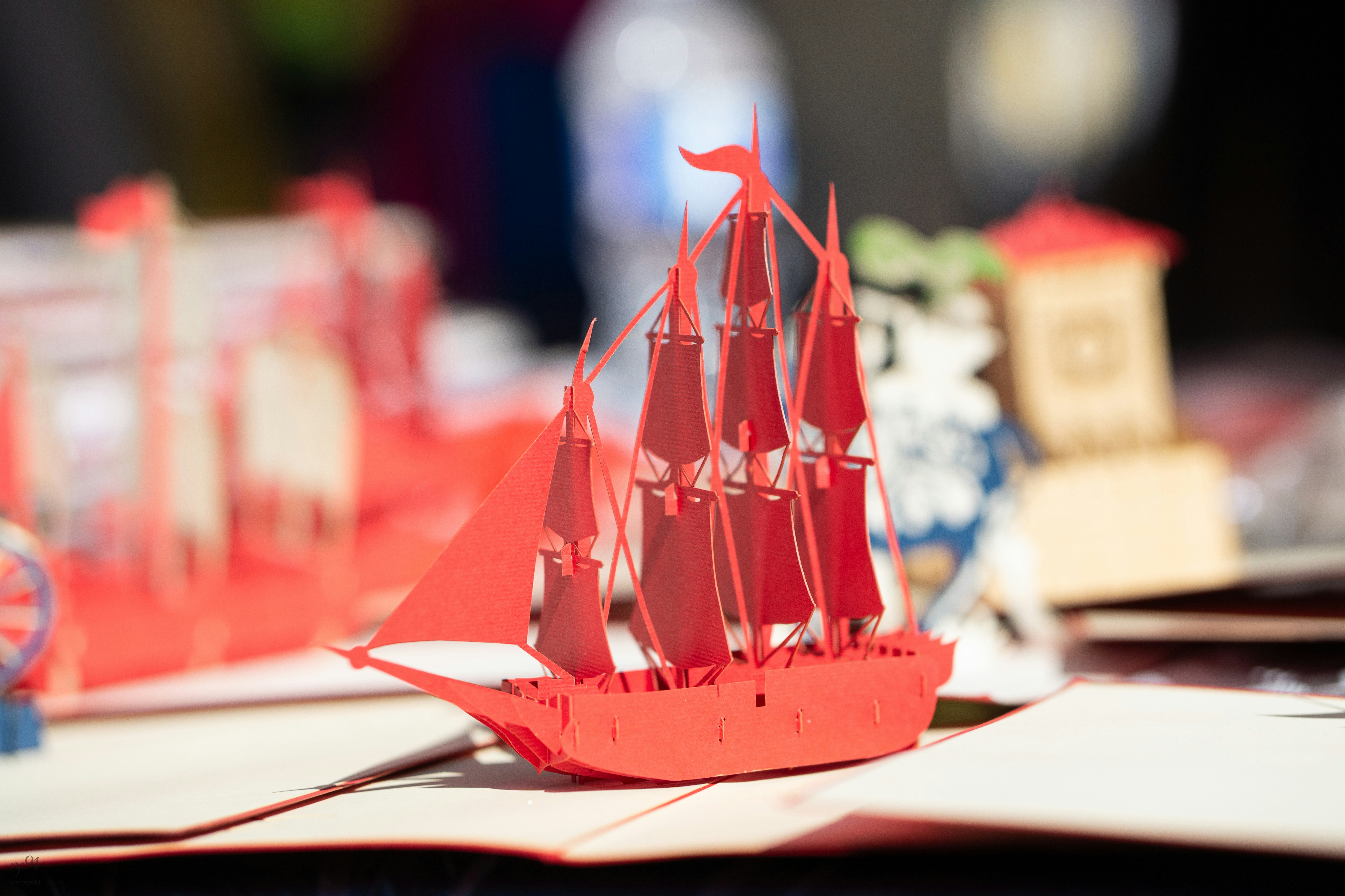 Red paper sailboat model with detailed sails.