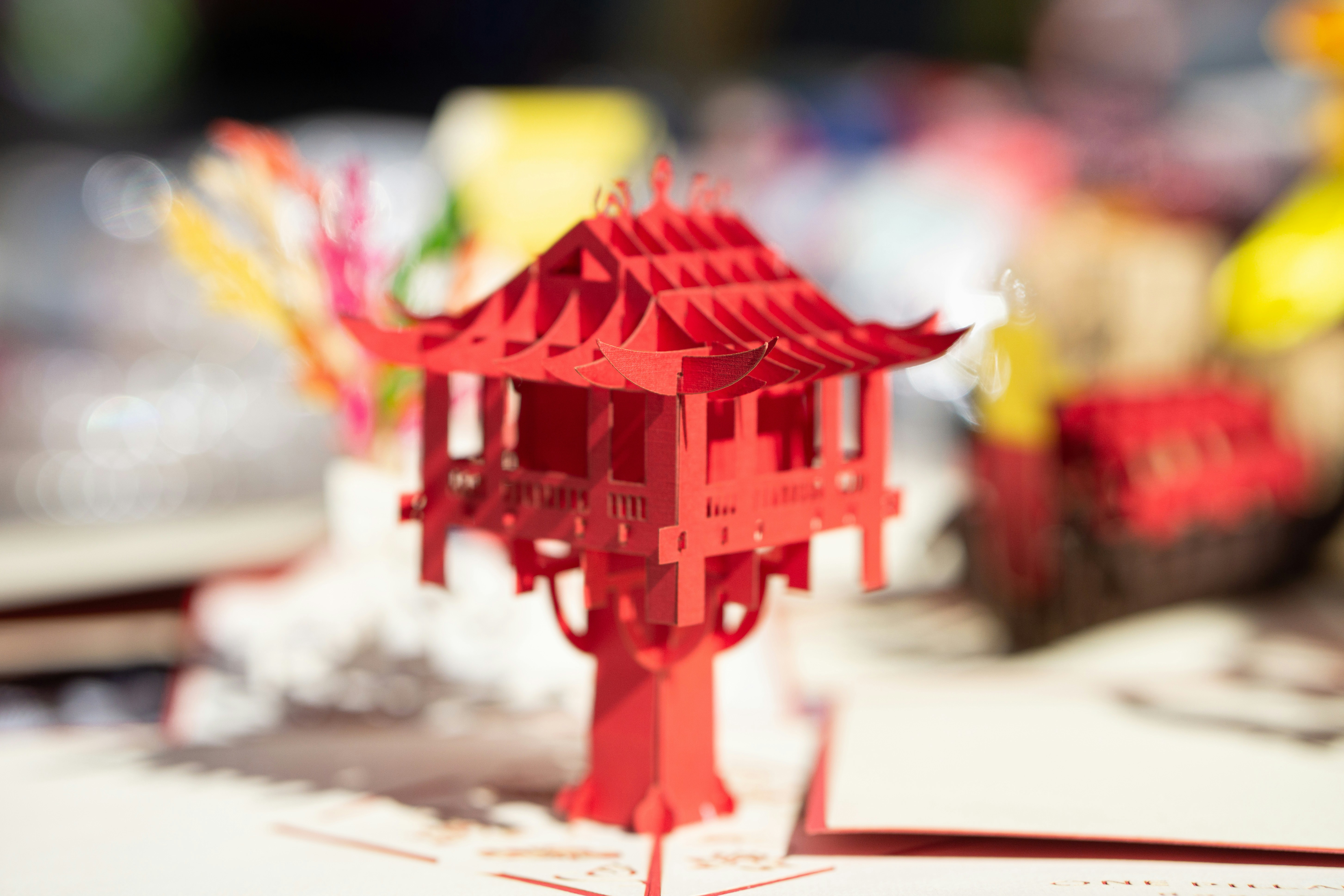 A small red paper pagoda on a white surface.