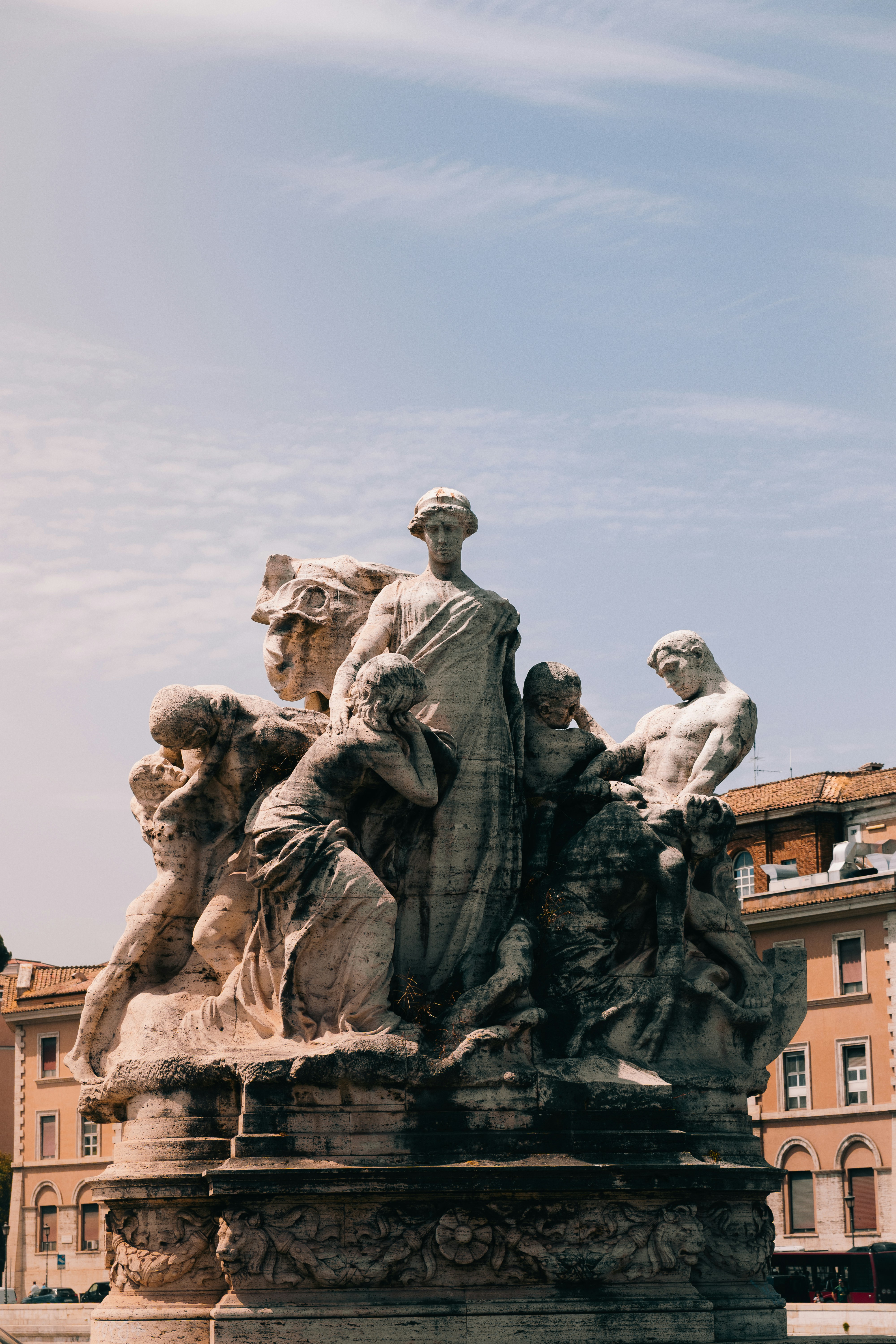 Intricate marble sculpture depicting figures in a moment of emotional connection, set against a backdrop of historical architecture.