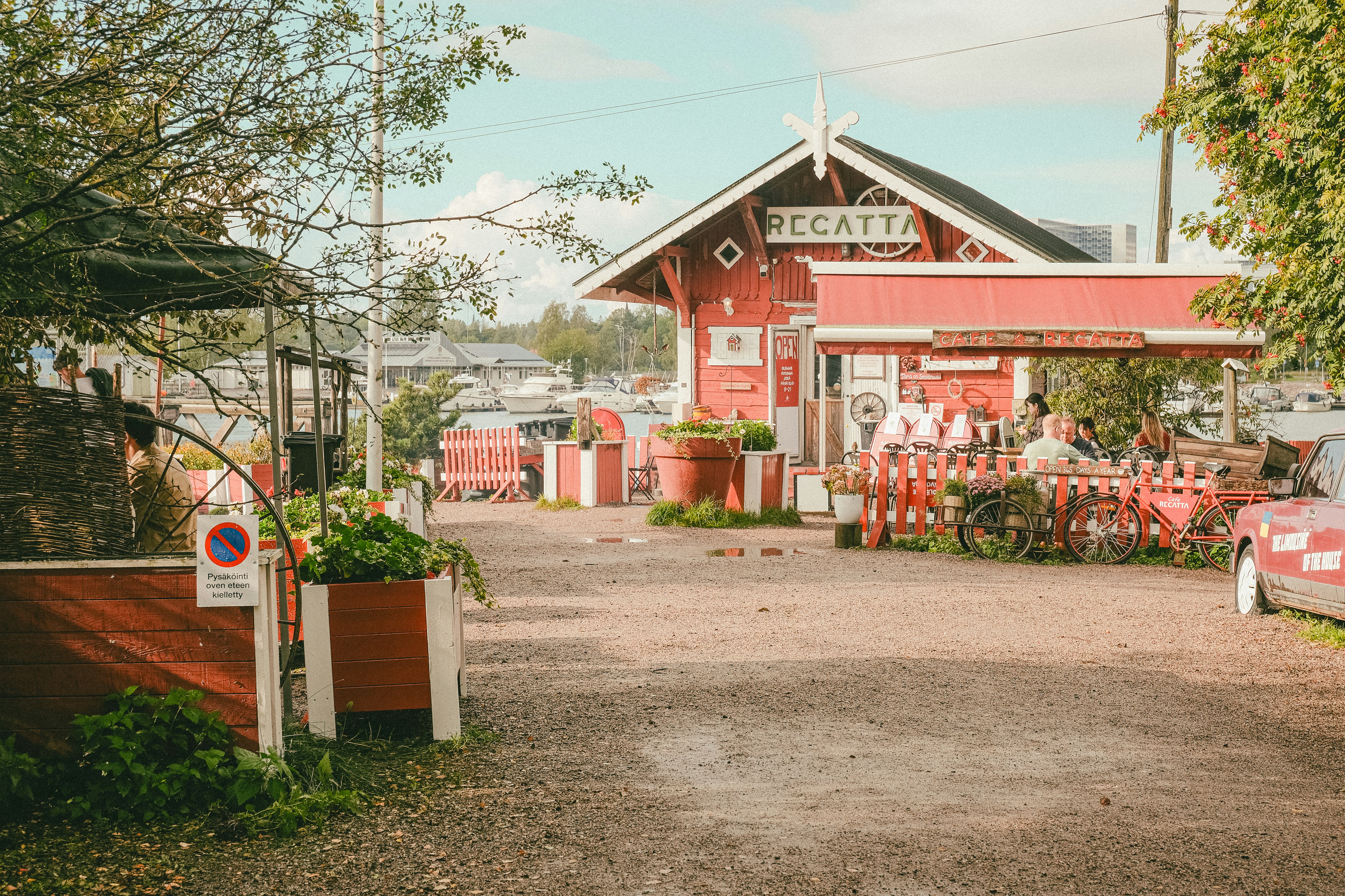 Cafe Regatta is located by the sea, close to Sibelius monument in Töölö. The traditional red cottage cafe has brought a part of Finnish countryside to the middle of Helsinki. | Red building with sign that says deccatta