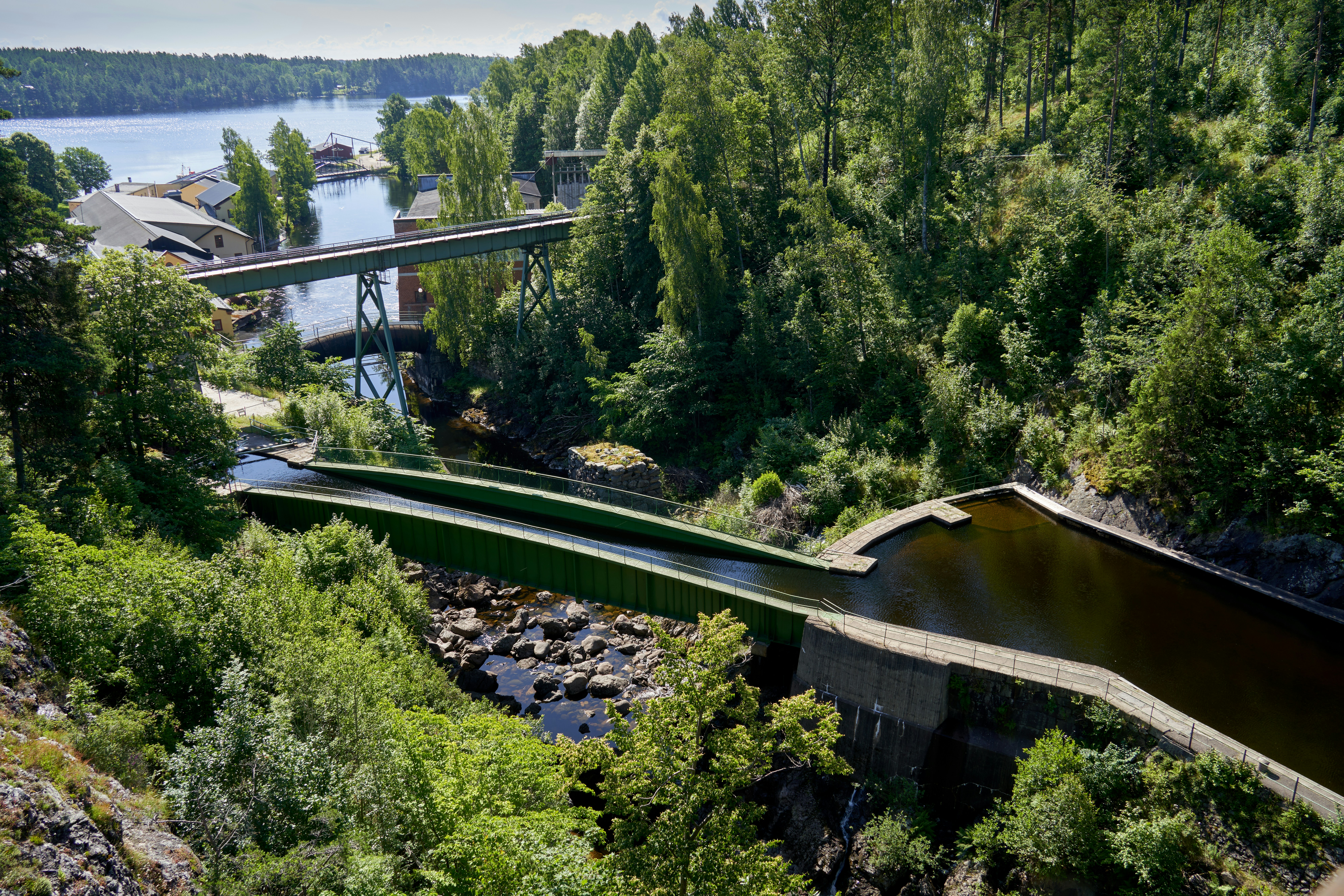Aqueduct in Håverud. This is the high point of the Dalsland canal route, attracting many tourists | Waterway flowing through a lush green forested landscape.