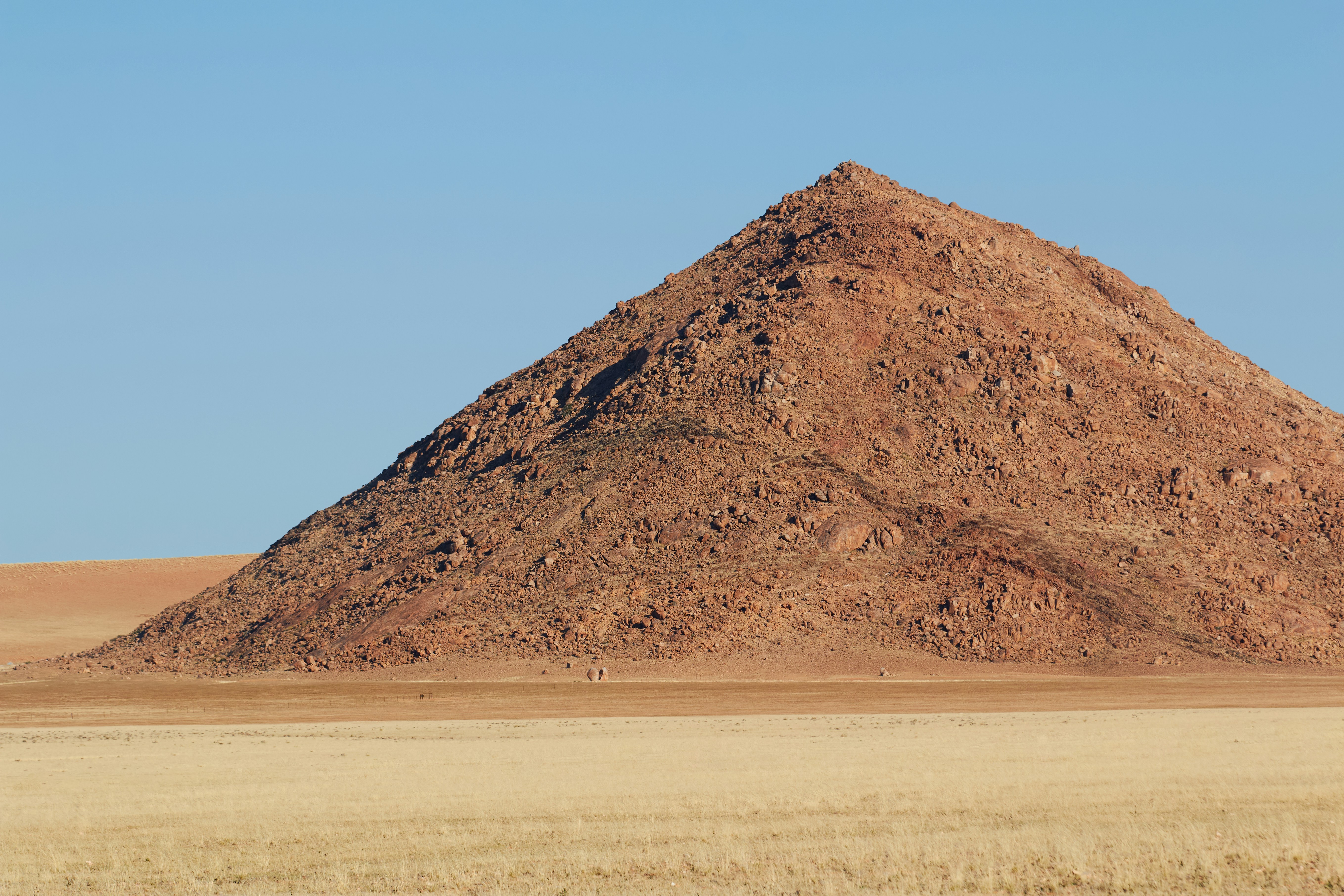 Namibia | A large, rocky hill under a clear blue sky