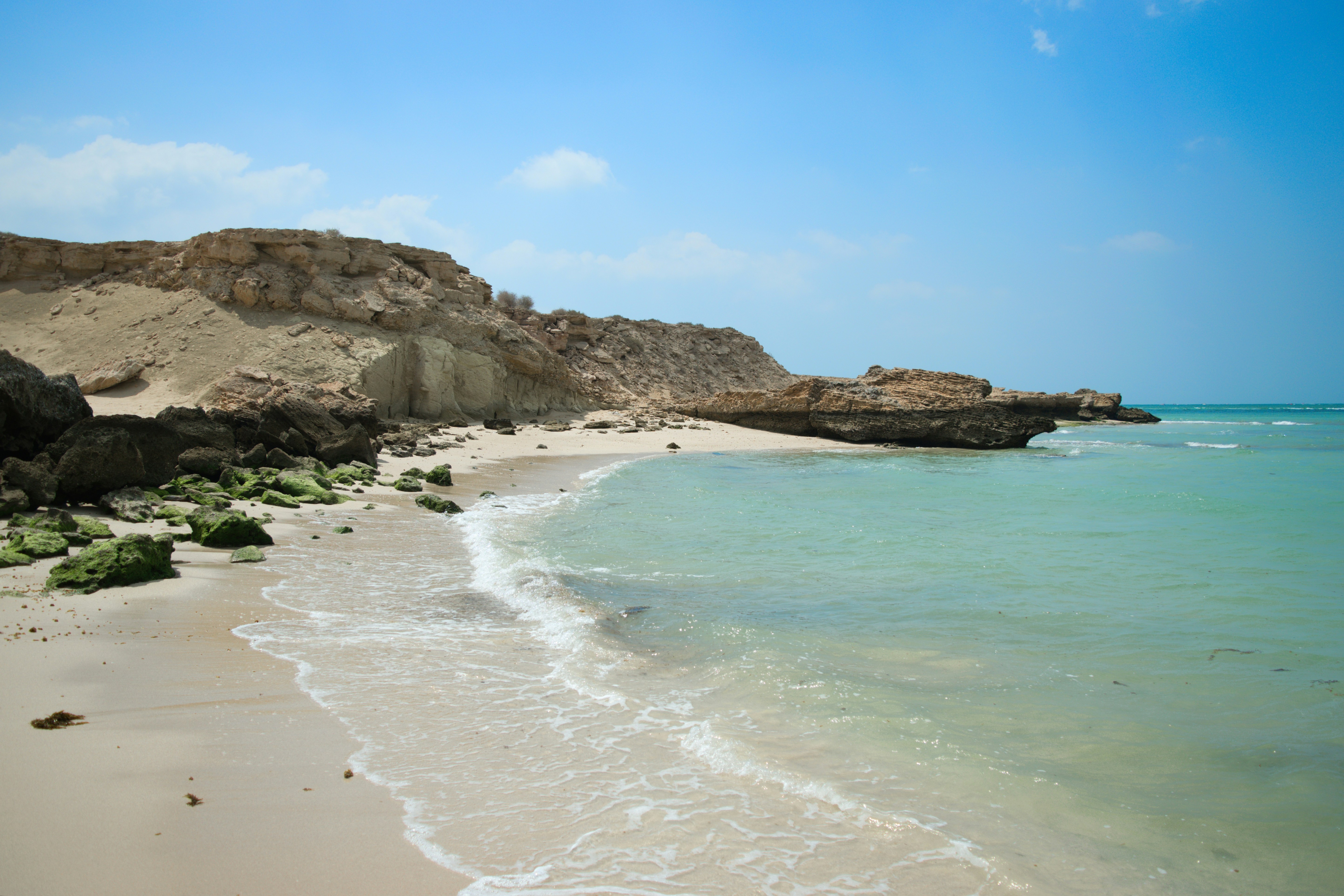 Sandy beach with rocky cliffs and turquoise water