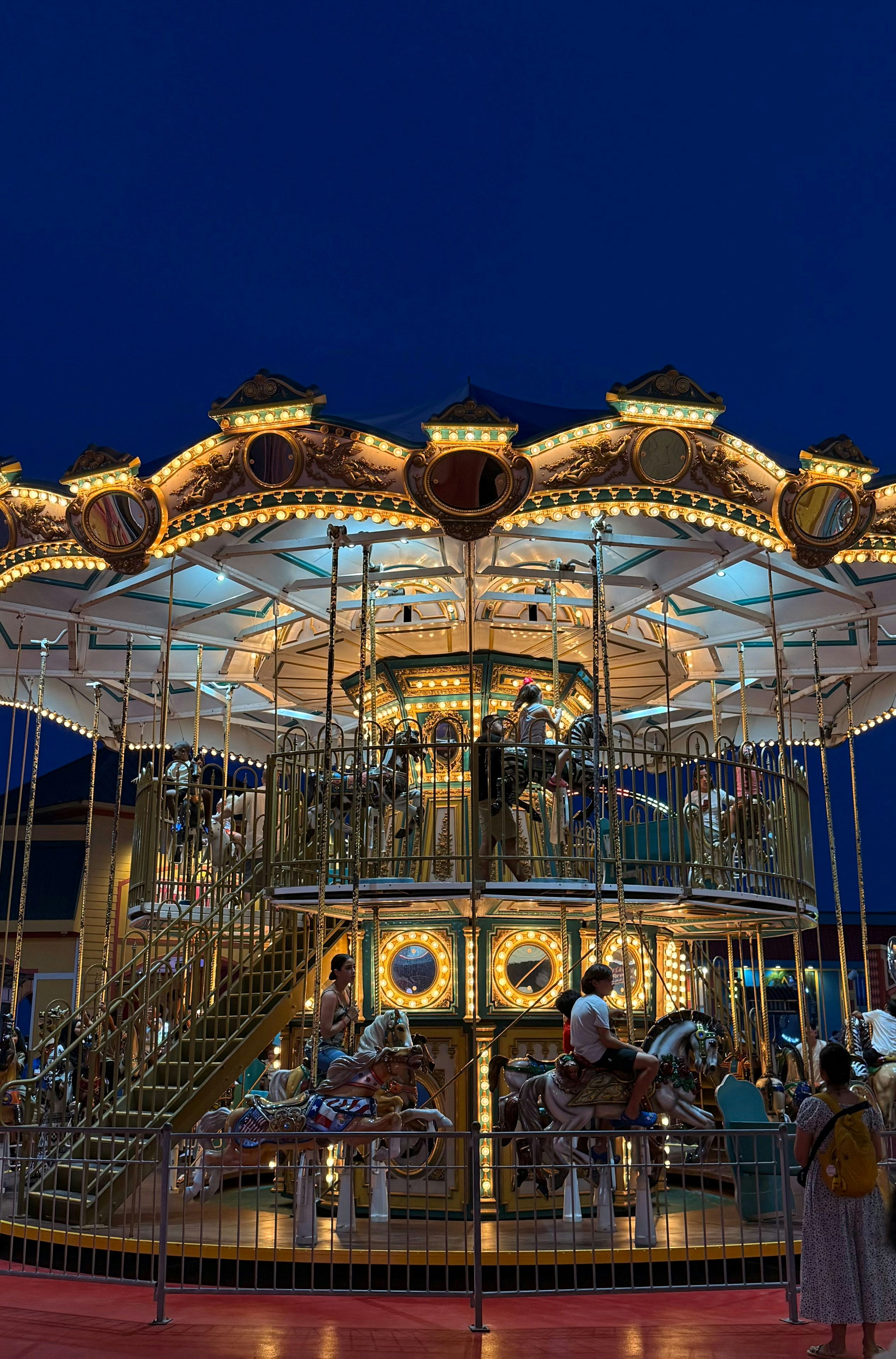 A brightly lit carousel at dusk with people riding. photo – Free Iphone ...
