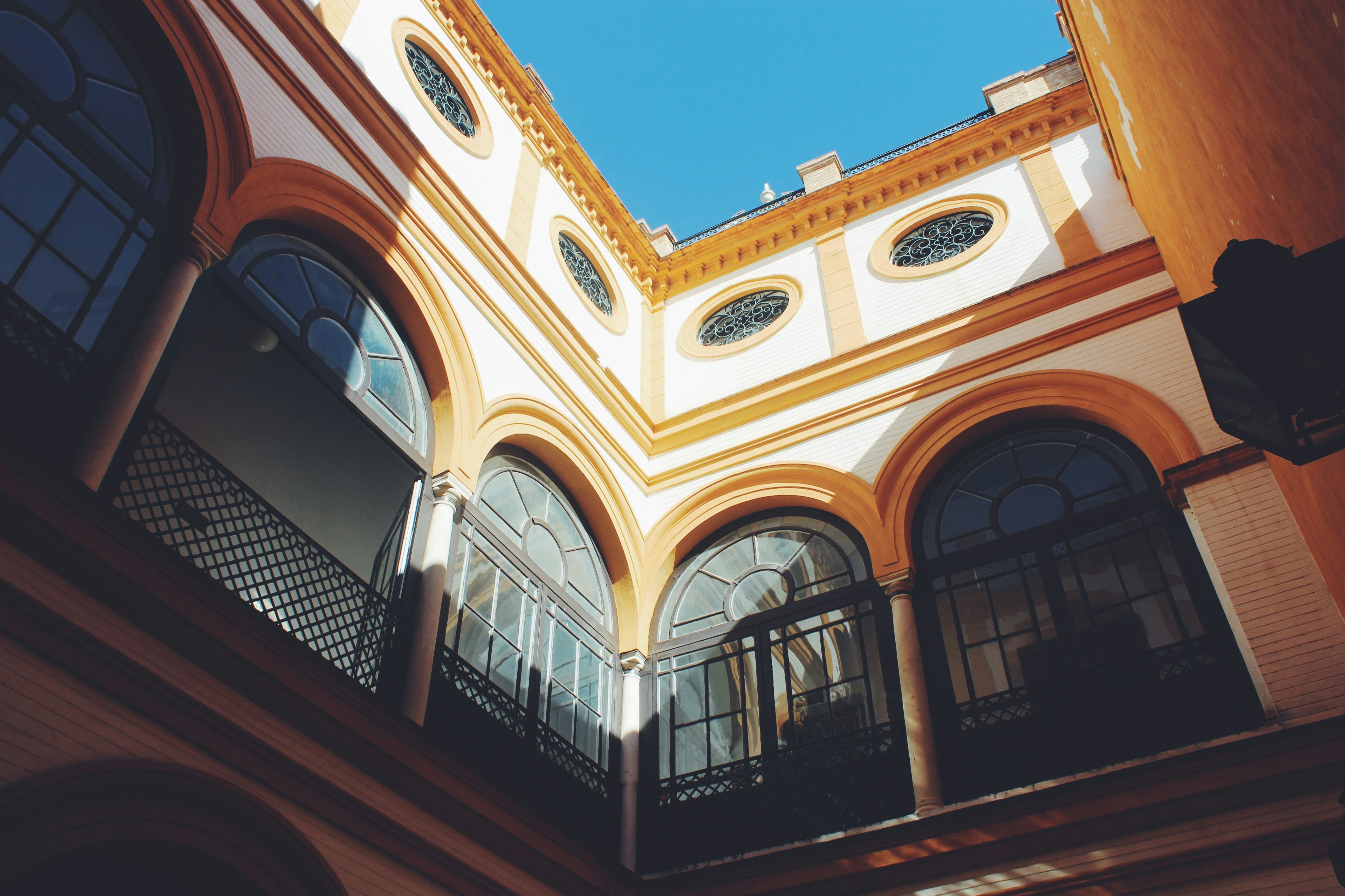Real Alcázar Sevilla España | Courtyard with arched windows and blue sky