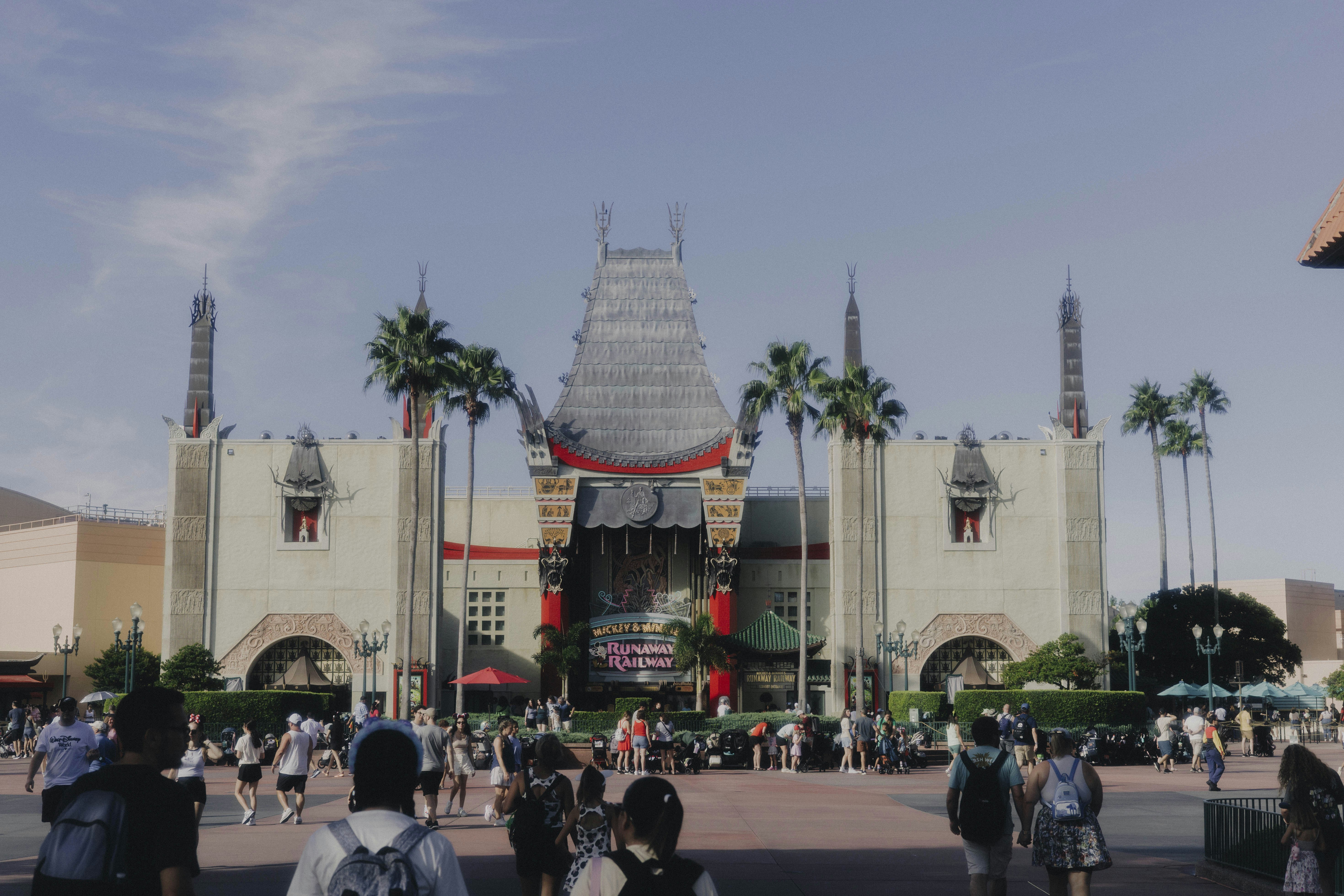 People walk in front of a grand building facade.