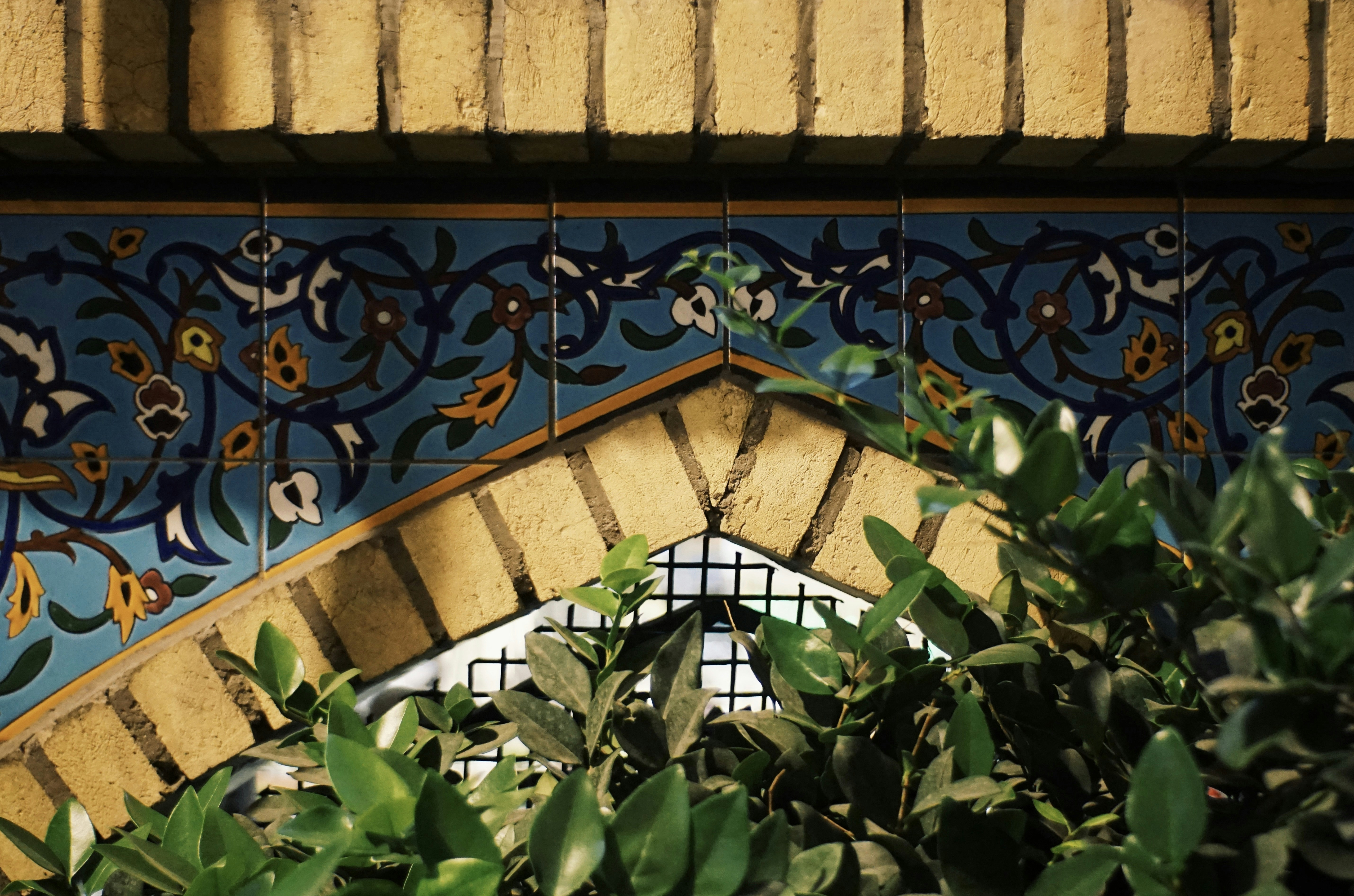 A quiet corner of peace and contemplation. | Detailed mosaic tiles with floral patterns and brickwork.