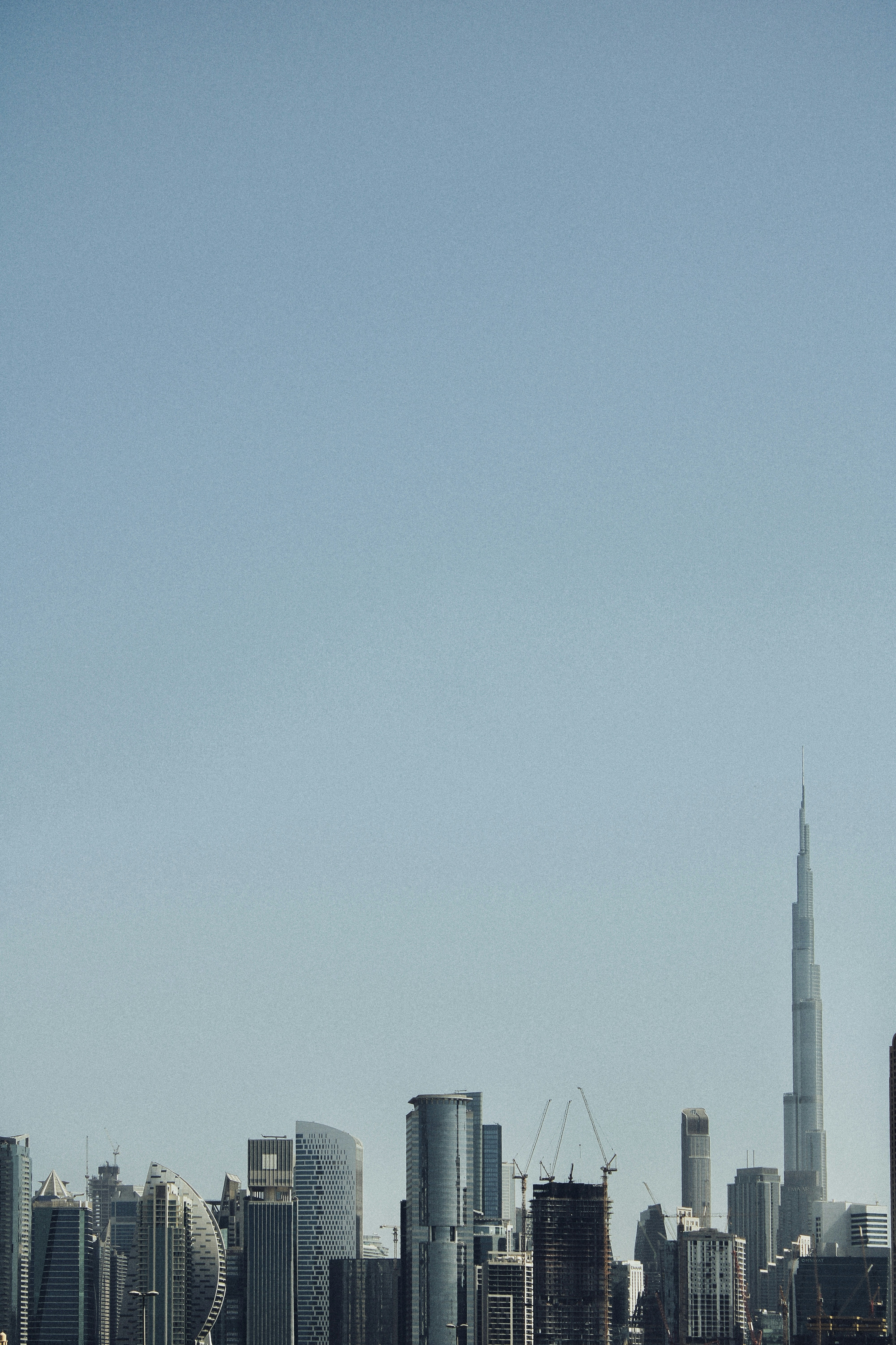 Dubai City View | Modern city skyline with tall skyscrapers under clear blue sky.