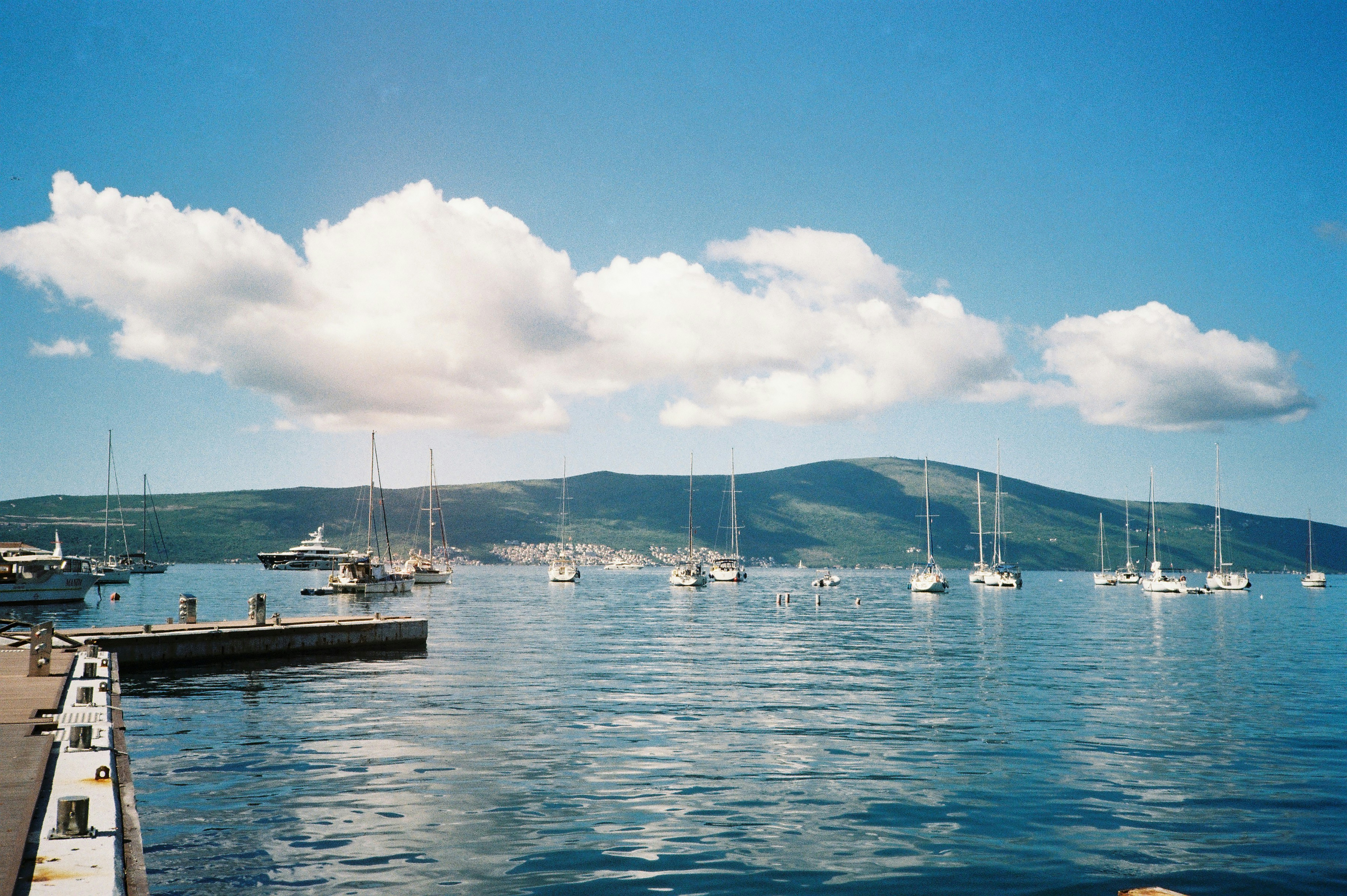 Attribution is appreciated (my Inst. @romi100gram) | Sailboats anchored in a calm bay with a hilly background.