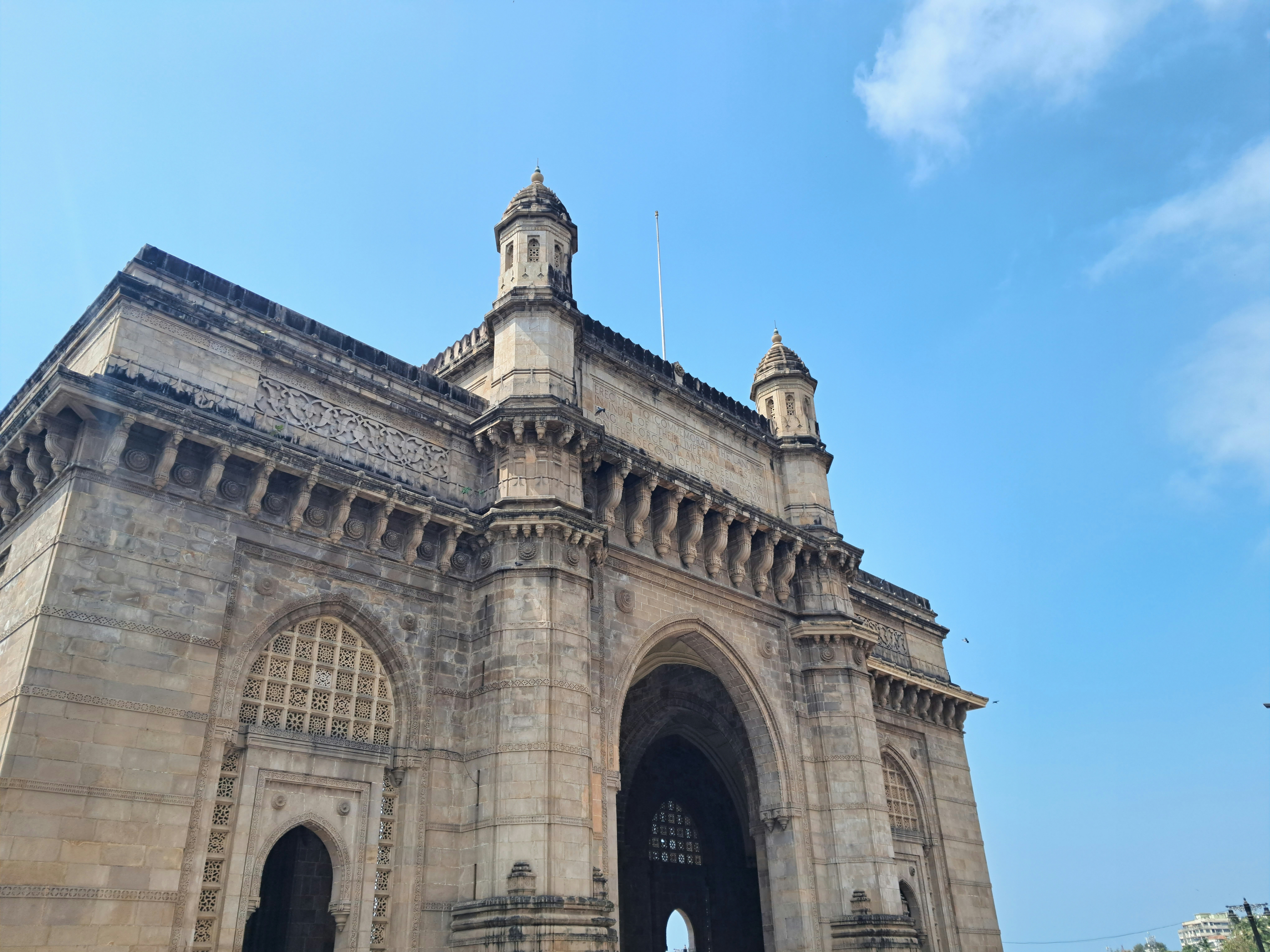 The gateway of india monument under a clear blue sky.