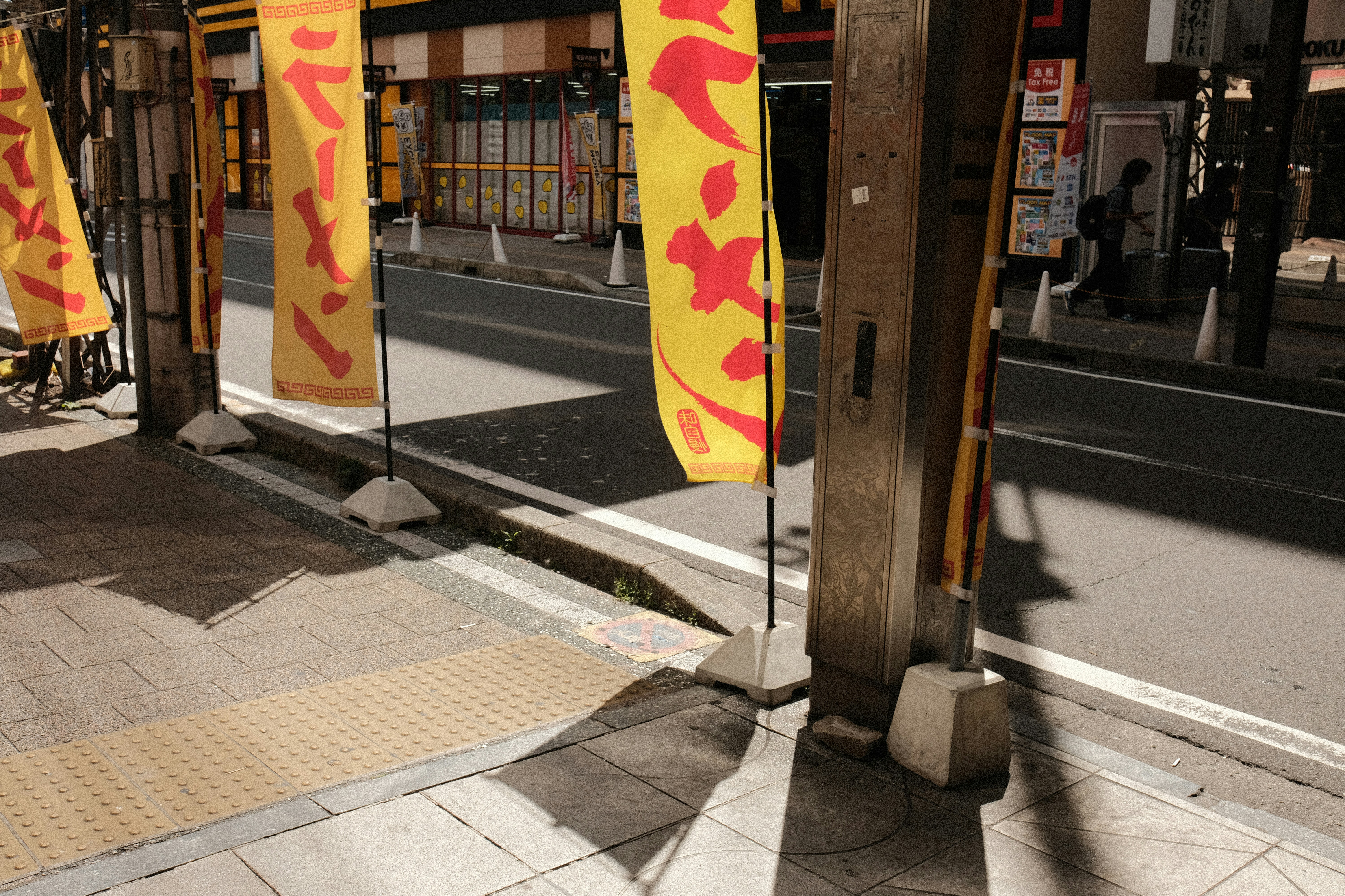 Yellow banners with japanese text on a street.