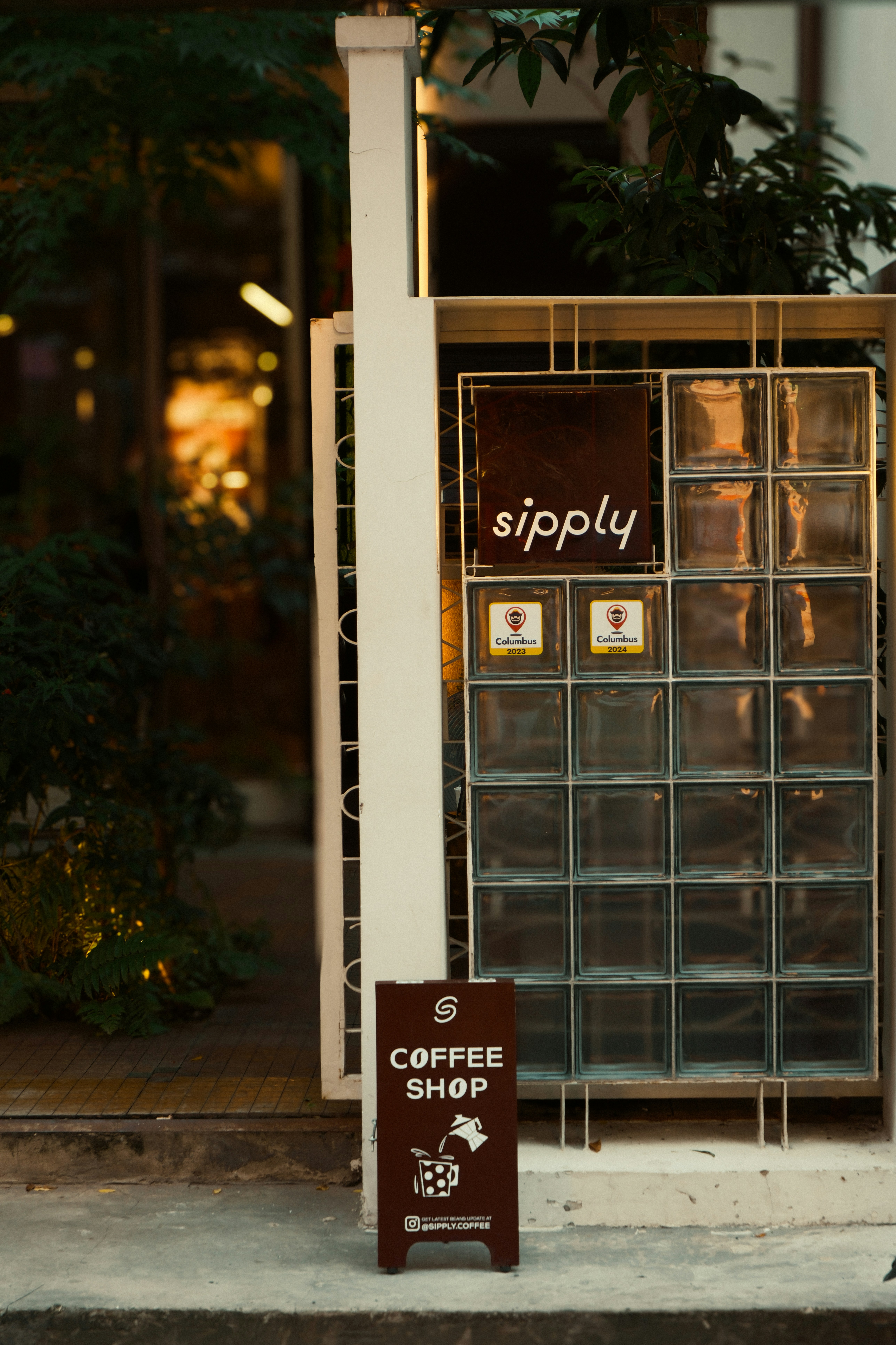 Coffee shop sign outside a building with glass blocks