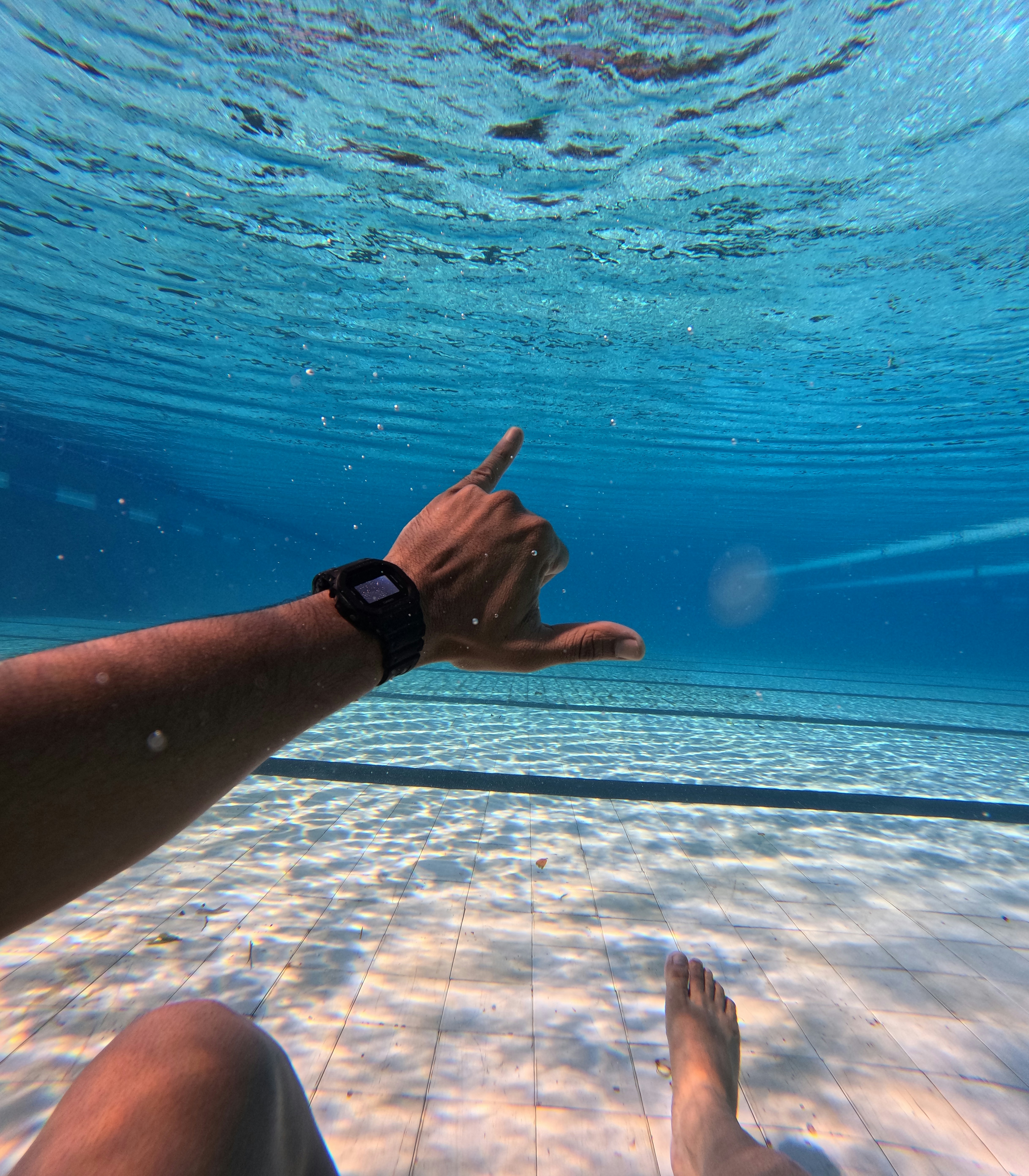 Treinamento apneia na piscina do Colégio Militar do Rio de Janeiro | Underwater view of a person signaling shaka sign