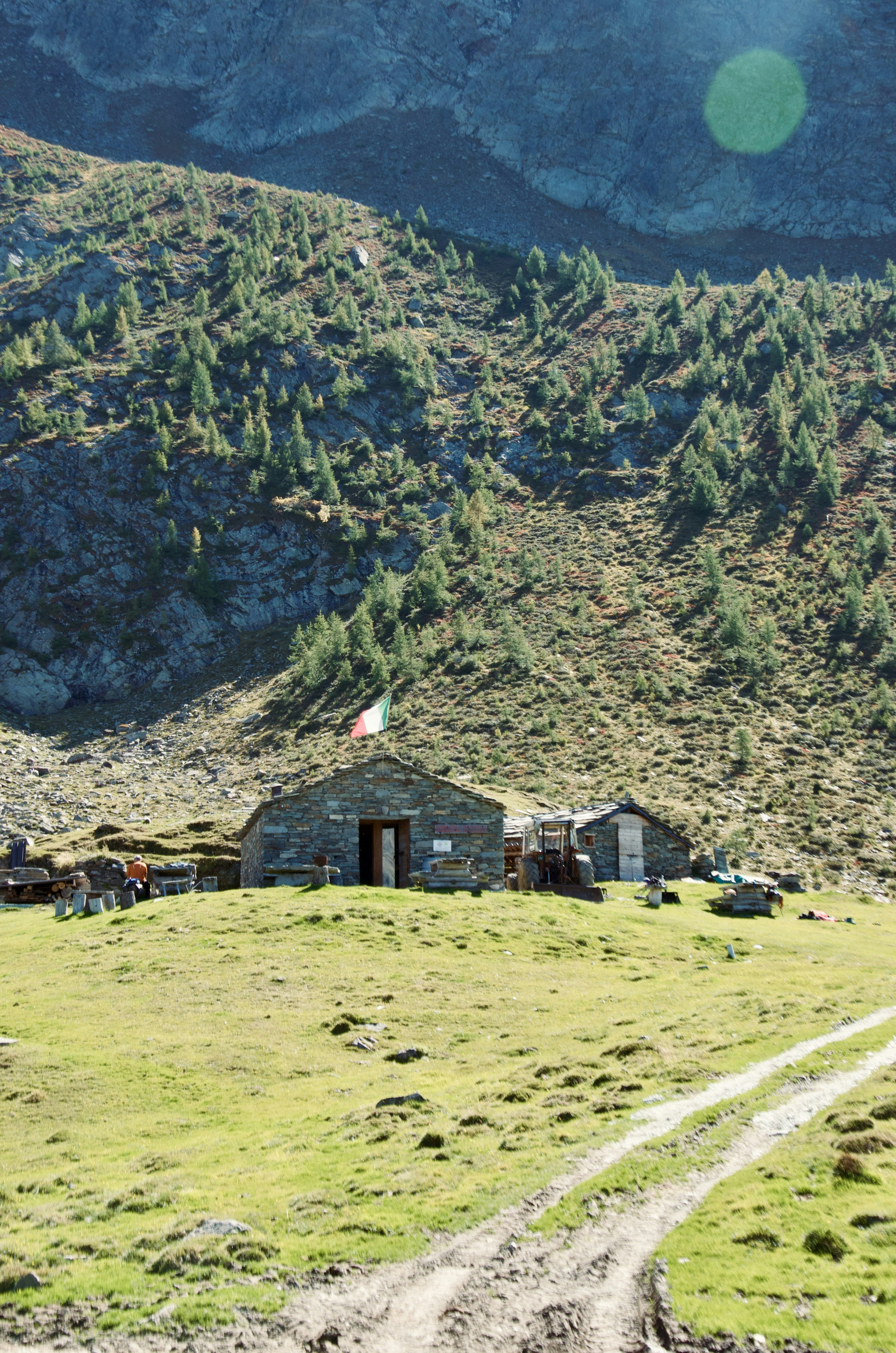 Stone buildings nestled in a green mountain landscape.