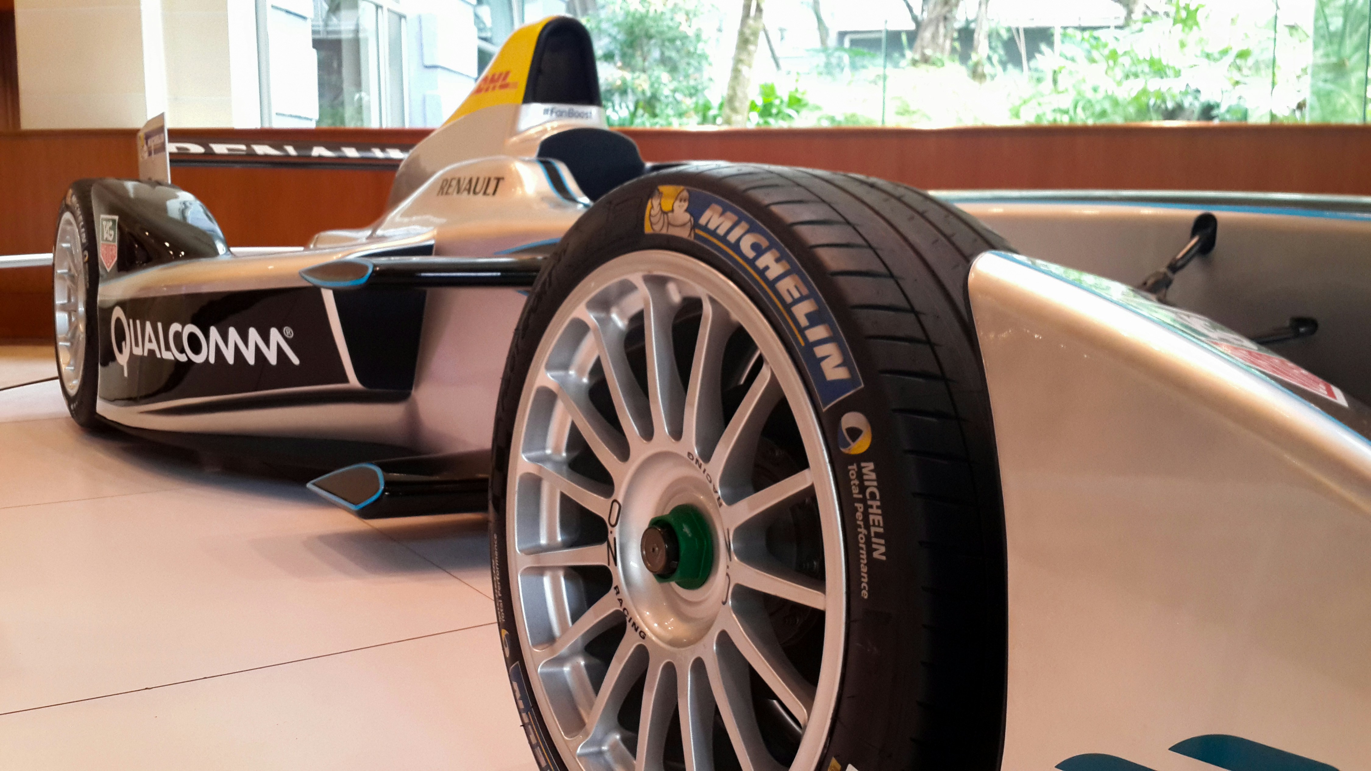 Formula One racing car in a hotel lobby | Close-up of a futuristic race car tire and wheel.