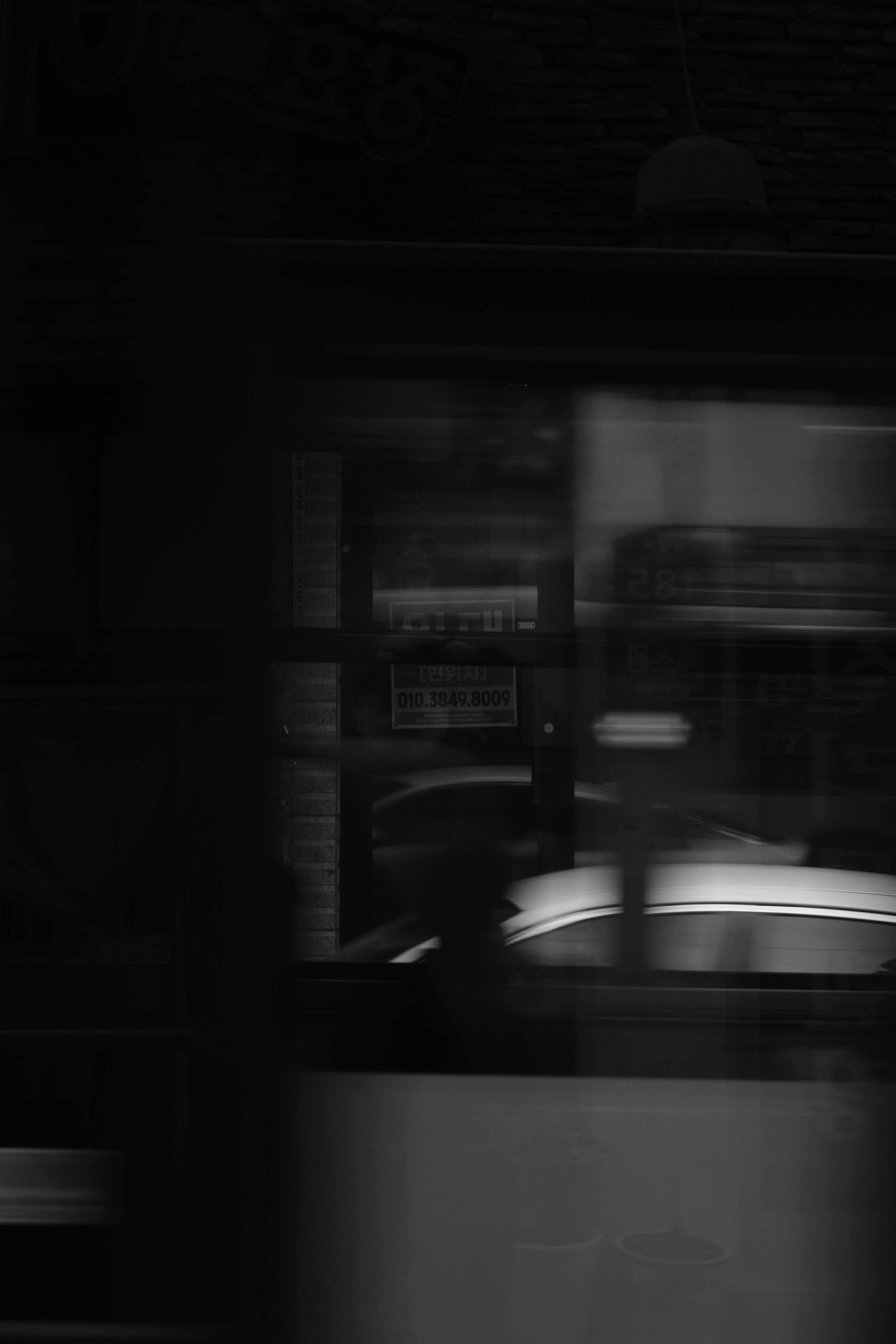 Blurred reflection of a person in a window at night