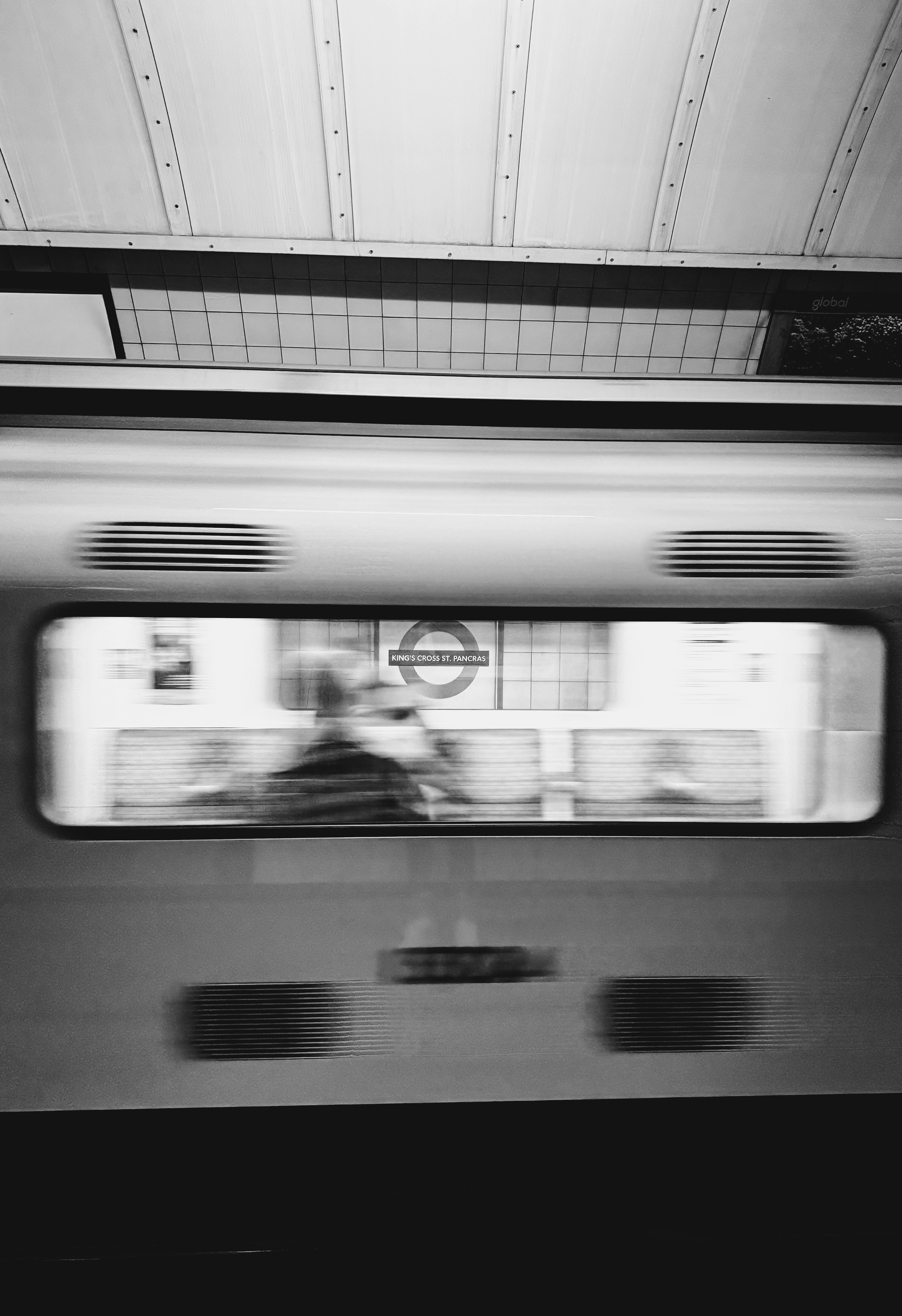 Person blurred inside a moving train carriage.