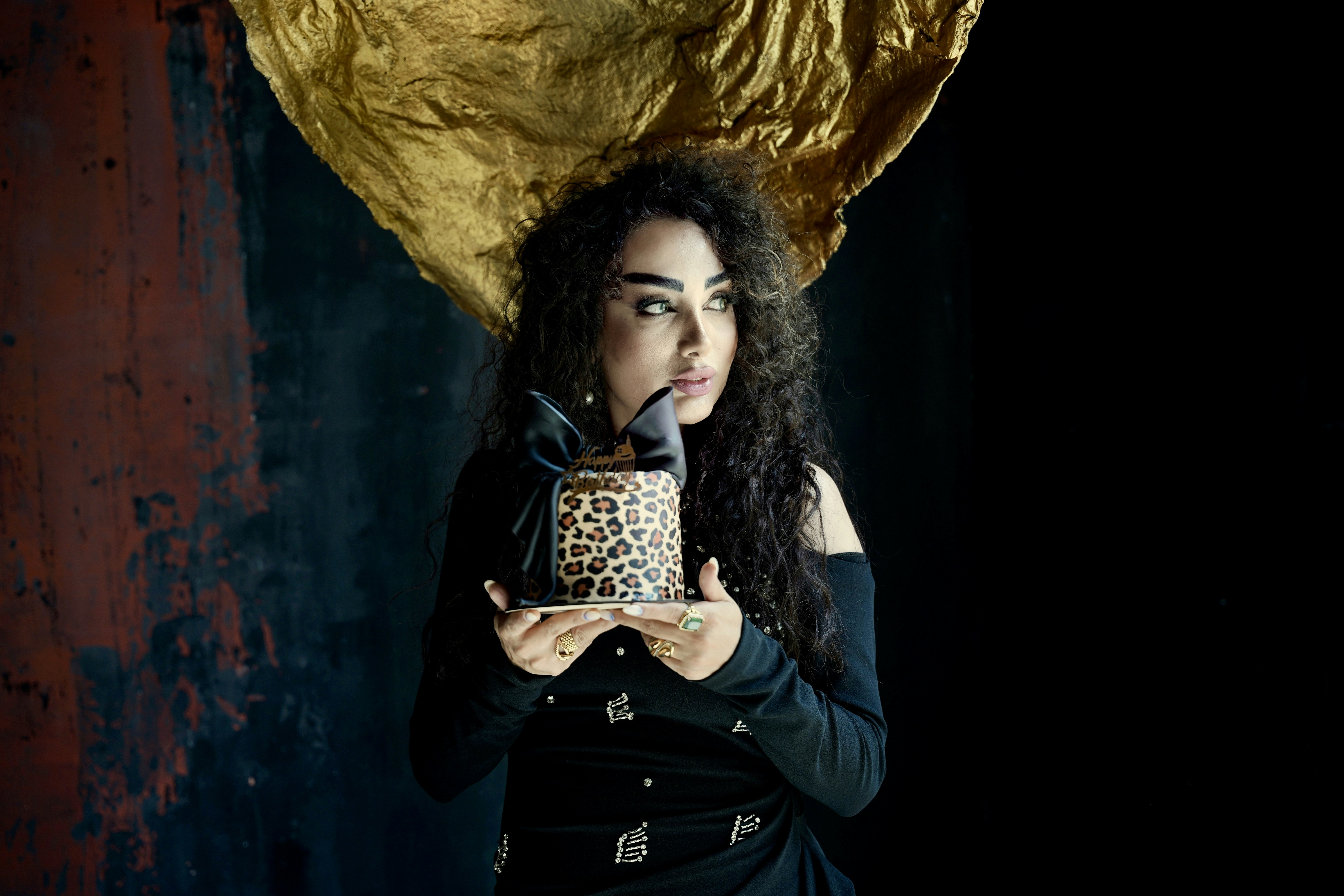 Woman holding a leopard print cake with gold accent